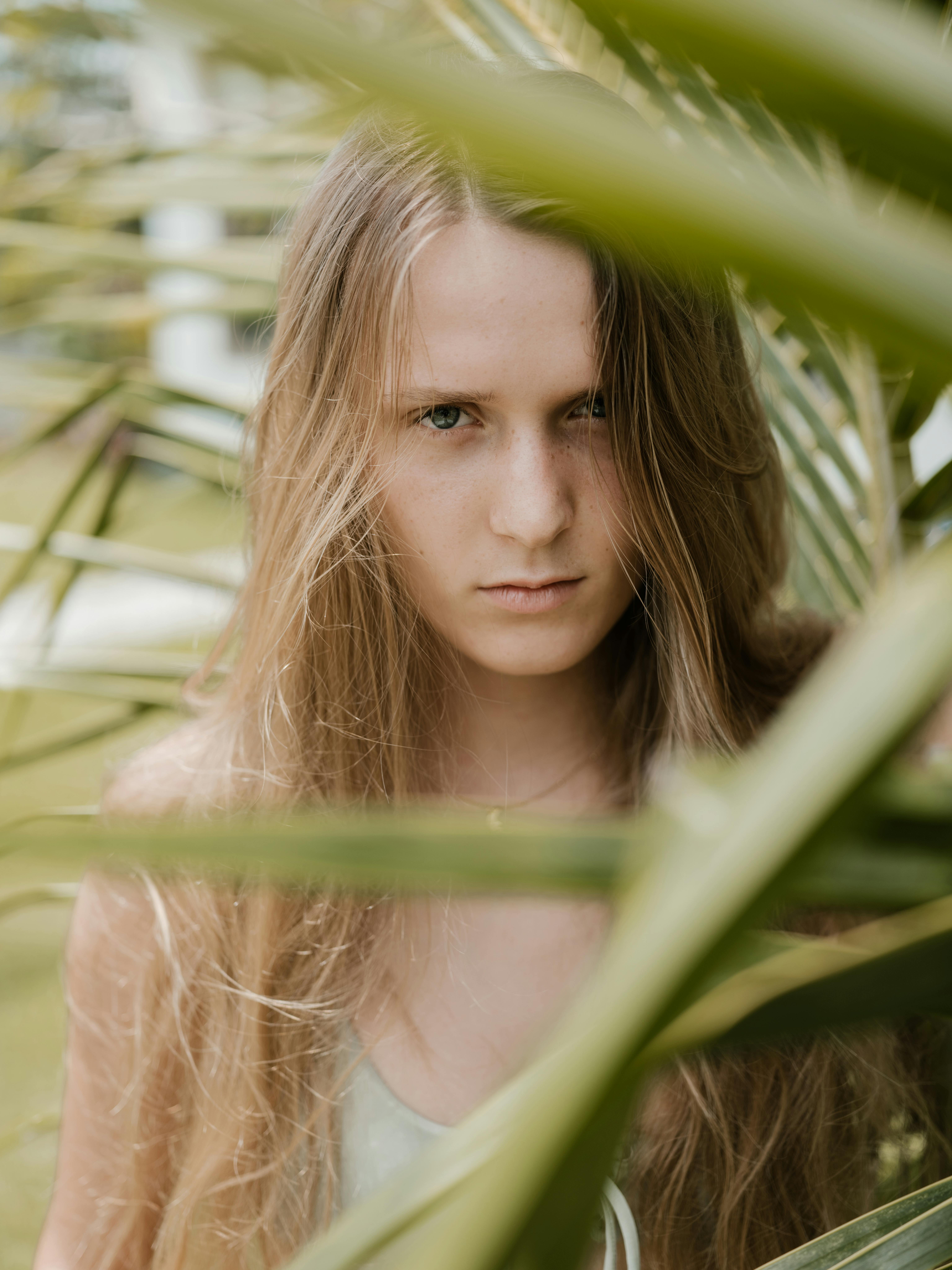 Emotionless woman looking at camera in garden · Free Stock Photo