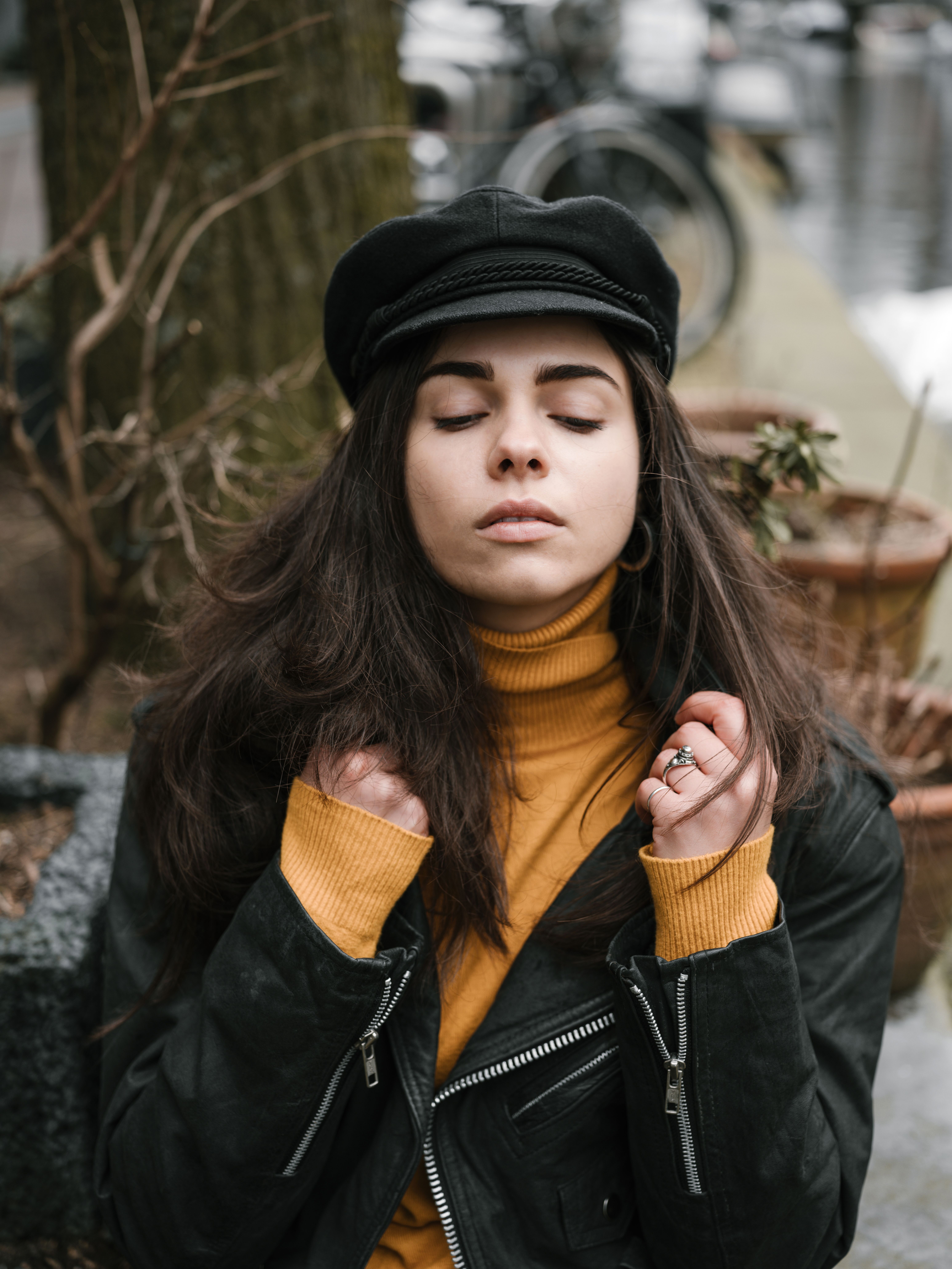 Young woman on city street near tree · Free Stock Photo