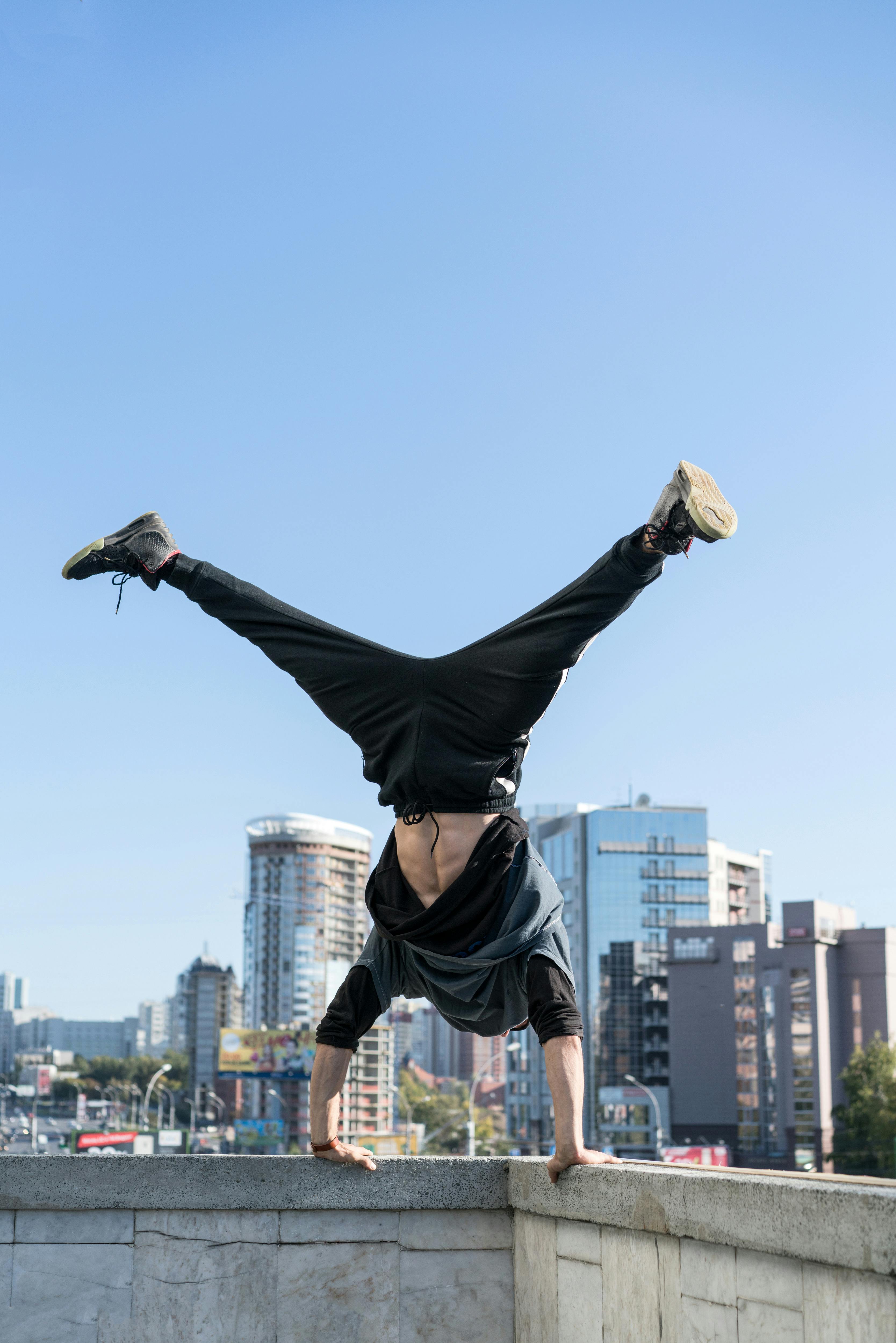 Roof climber standing upside down on roof edge · Free Stock Photo