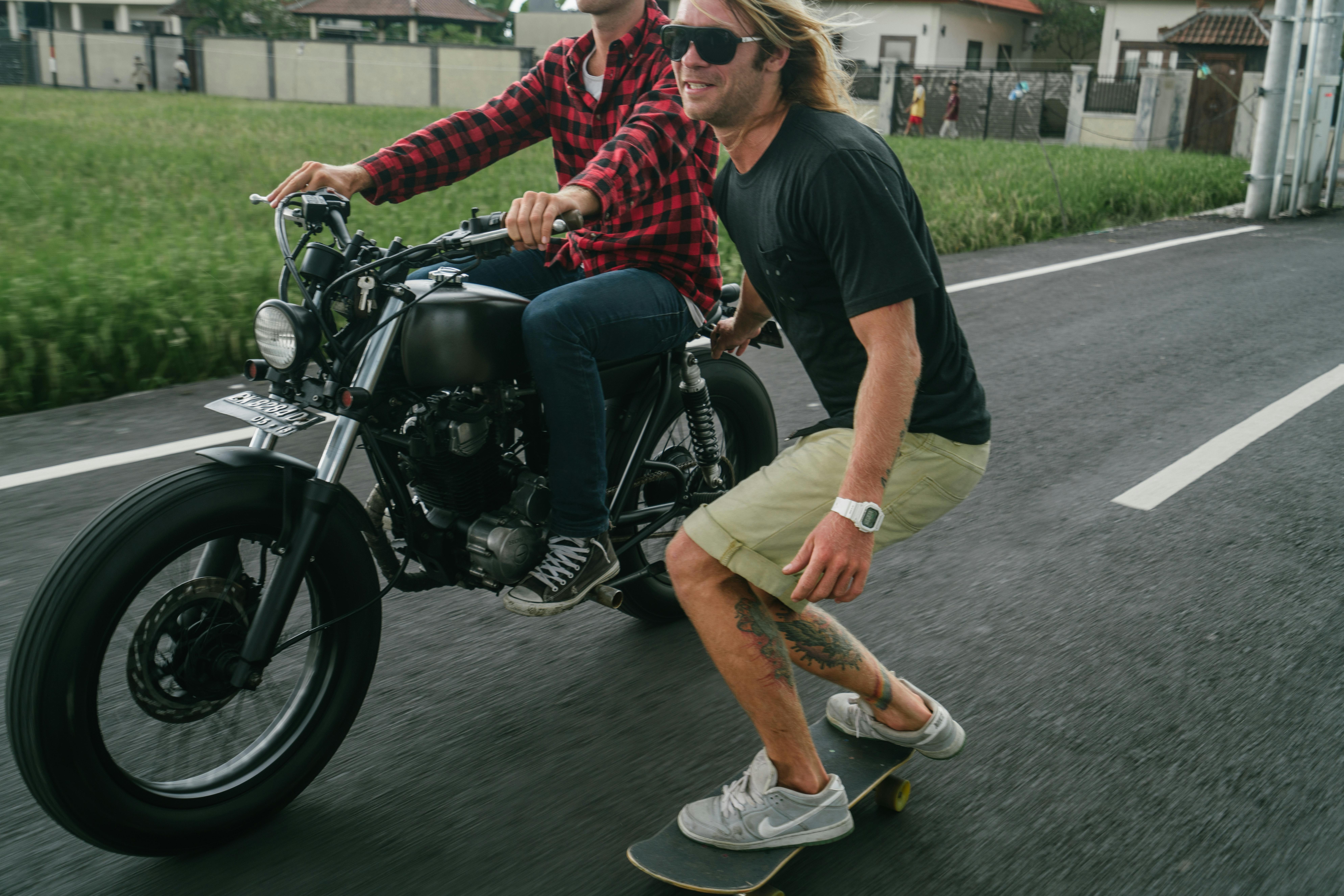 Crop hipster on skateboard riding with friend on motorbike · Free Stock ...
