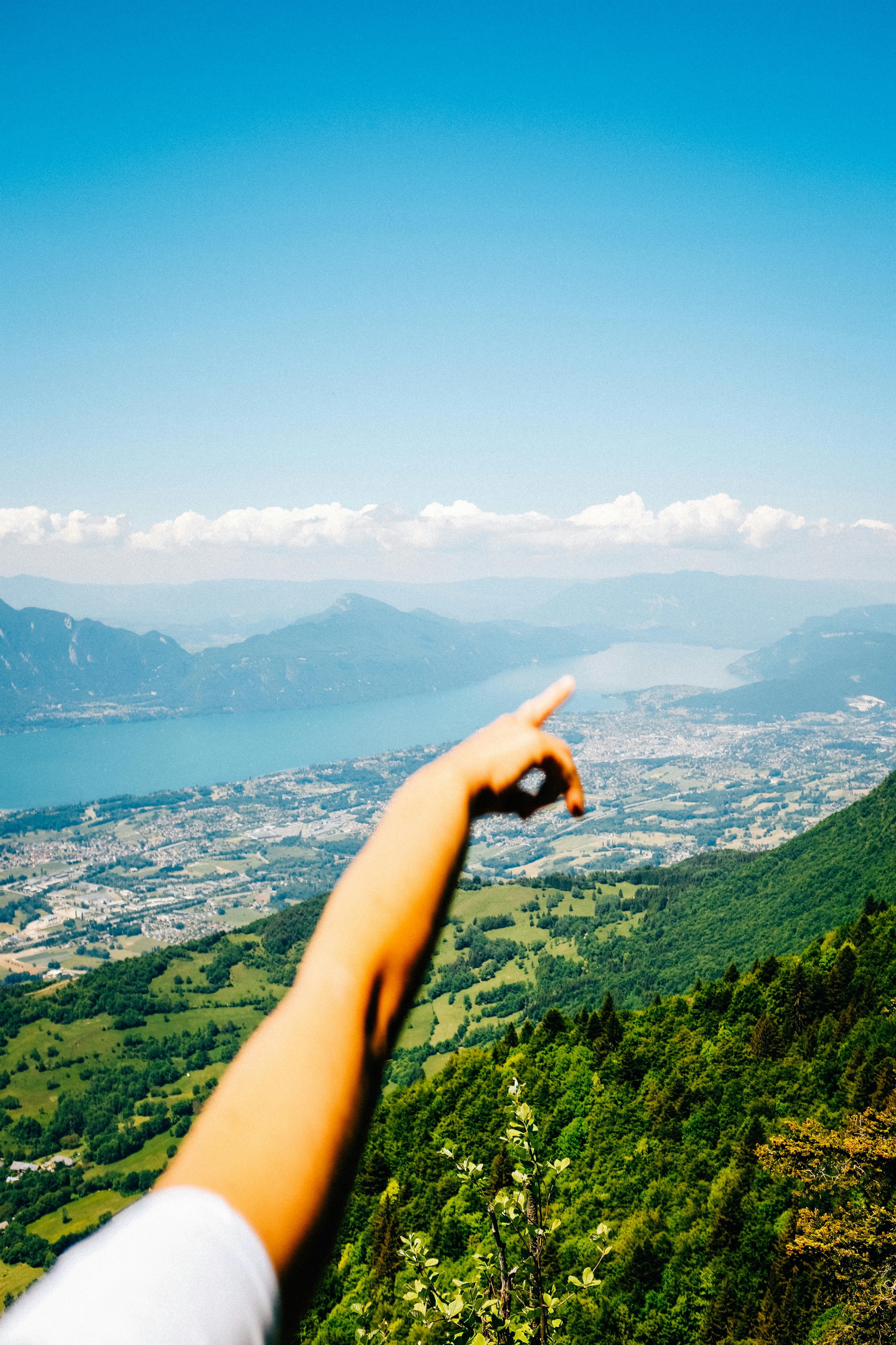 Young traveler pointing at distance standing in mountainous area · Free ...