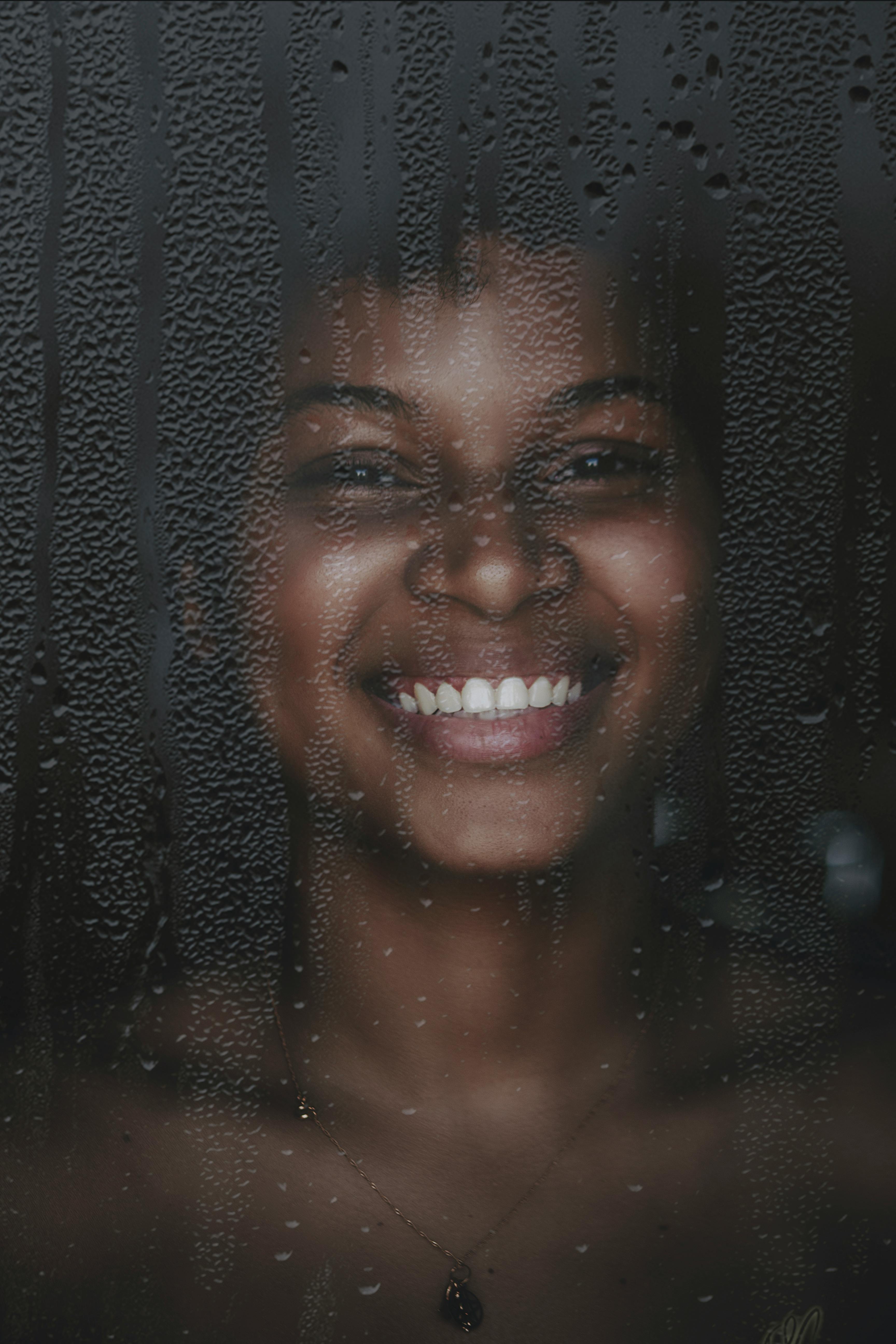 Smiling Woman Behind a Window · Free Stock Photo