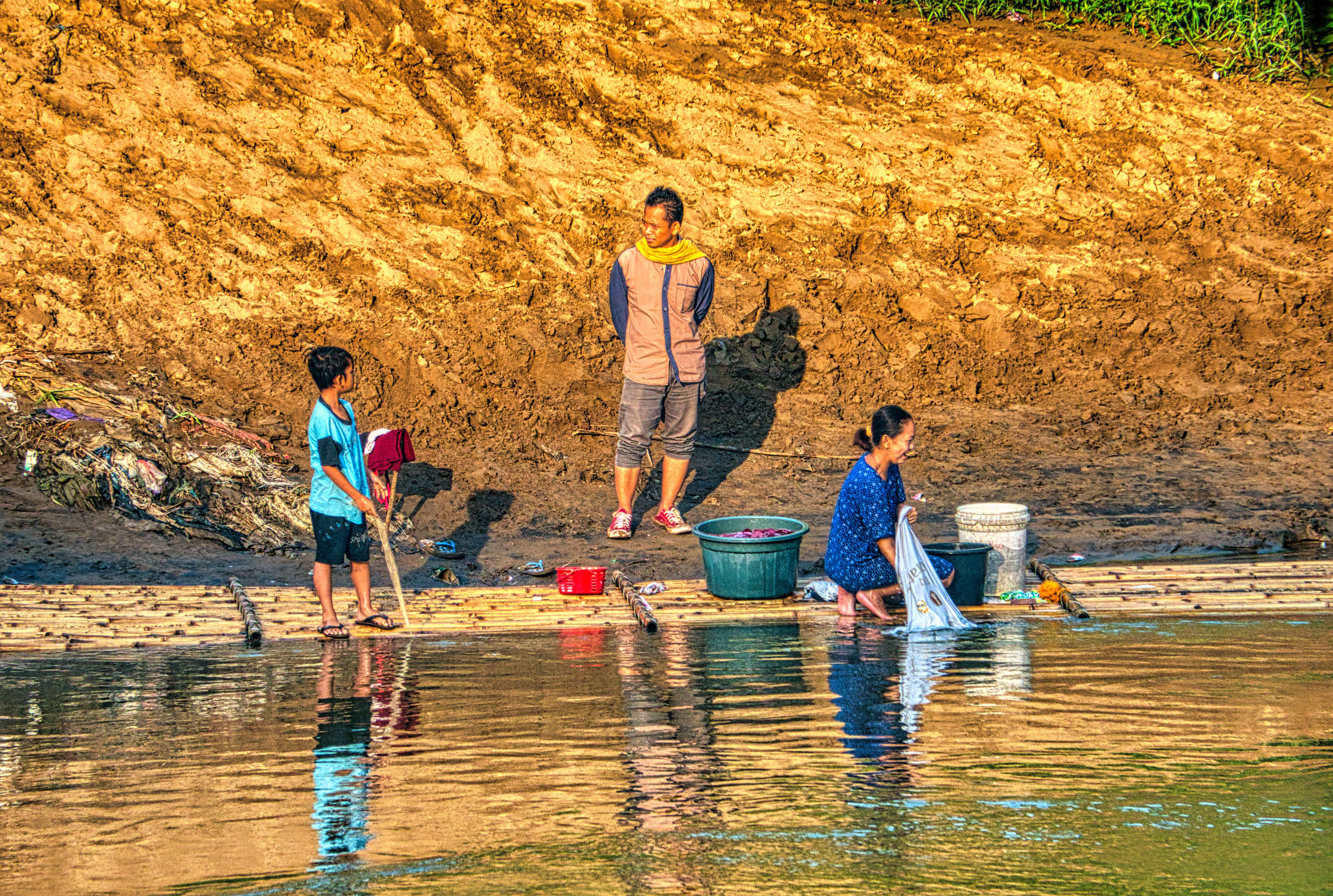 A Family Washing Clothes in the River · Free Stock Photo