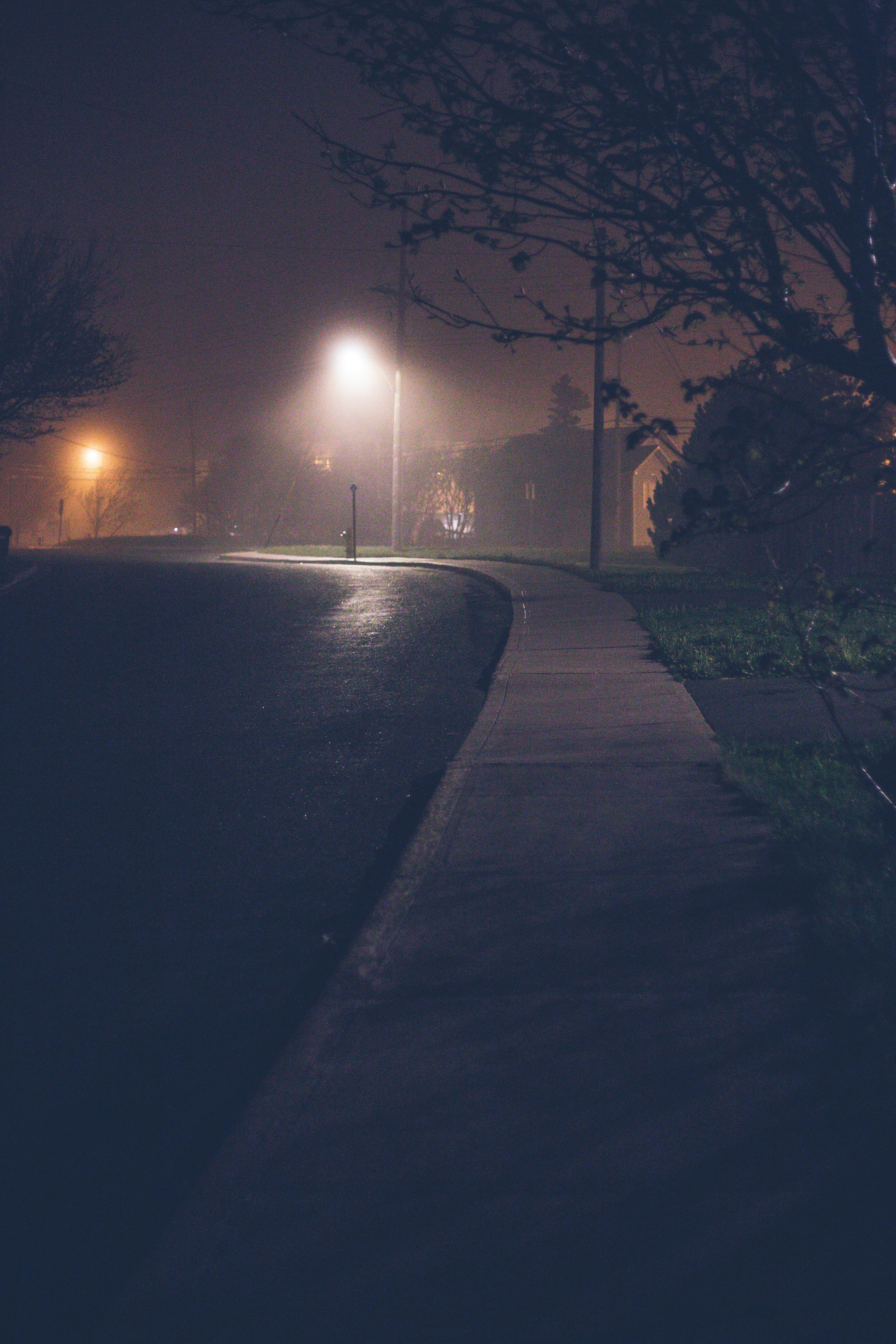 Empty sidewalk near road illuminated by street lights at night · Free ...