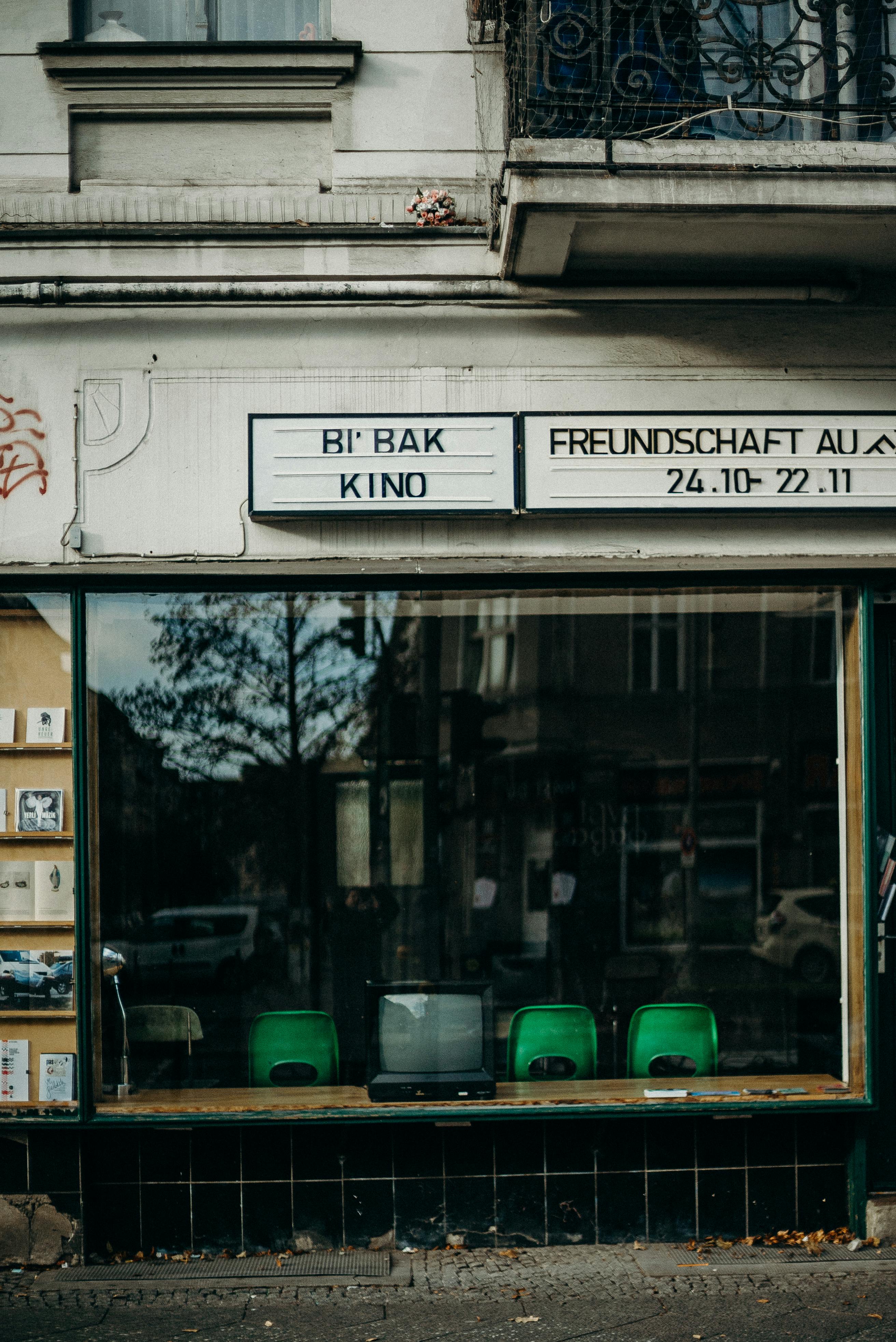 Green Plastic Trash Bin Beside Glass Window · Free Stock Photo