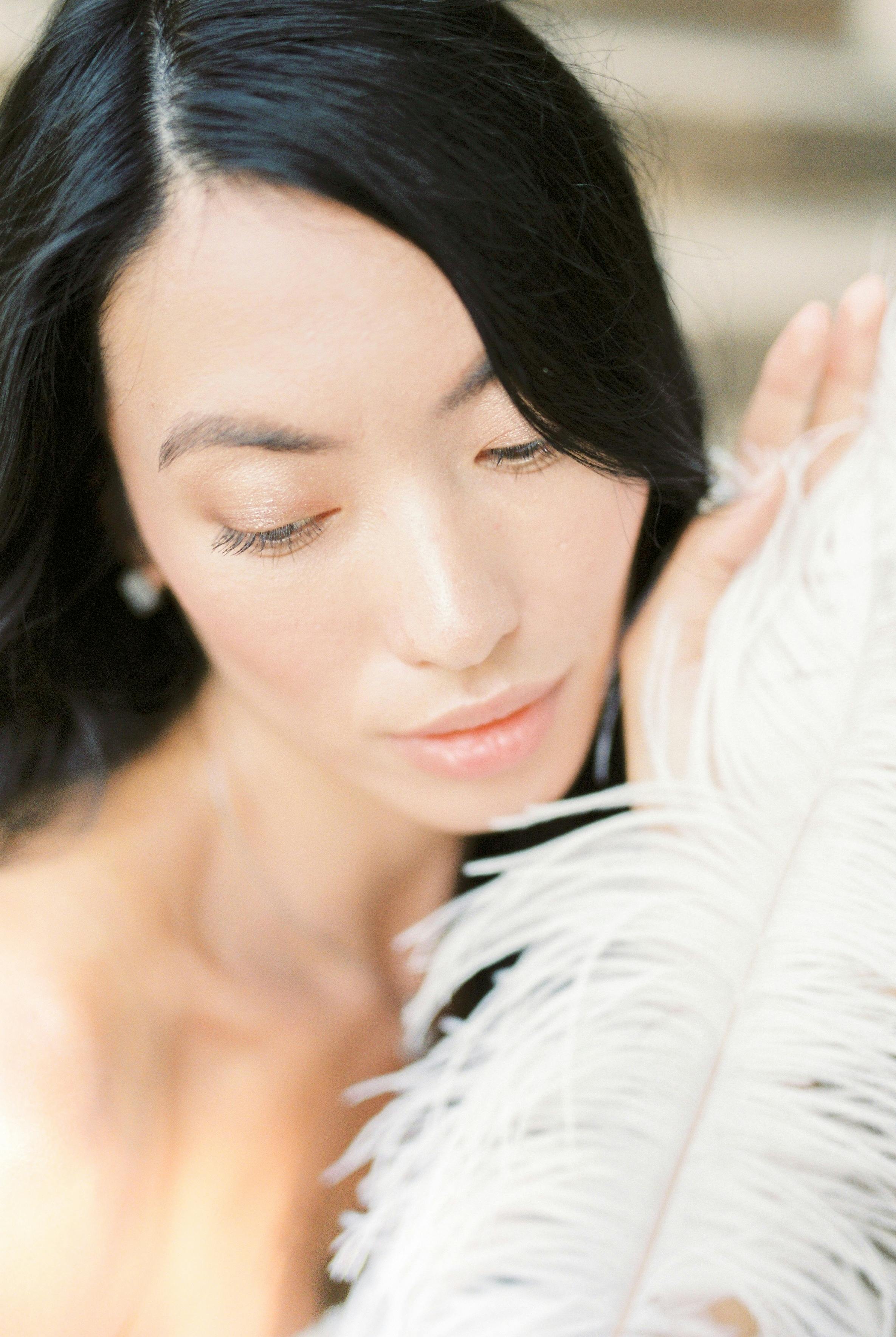 A Woman Holding White Feather · Free Stock Photo