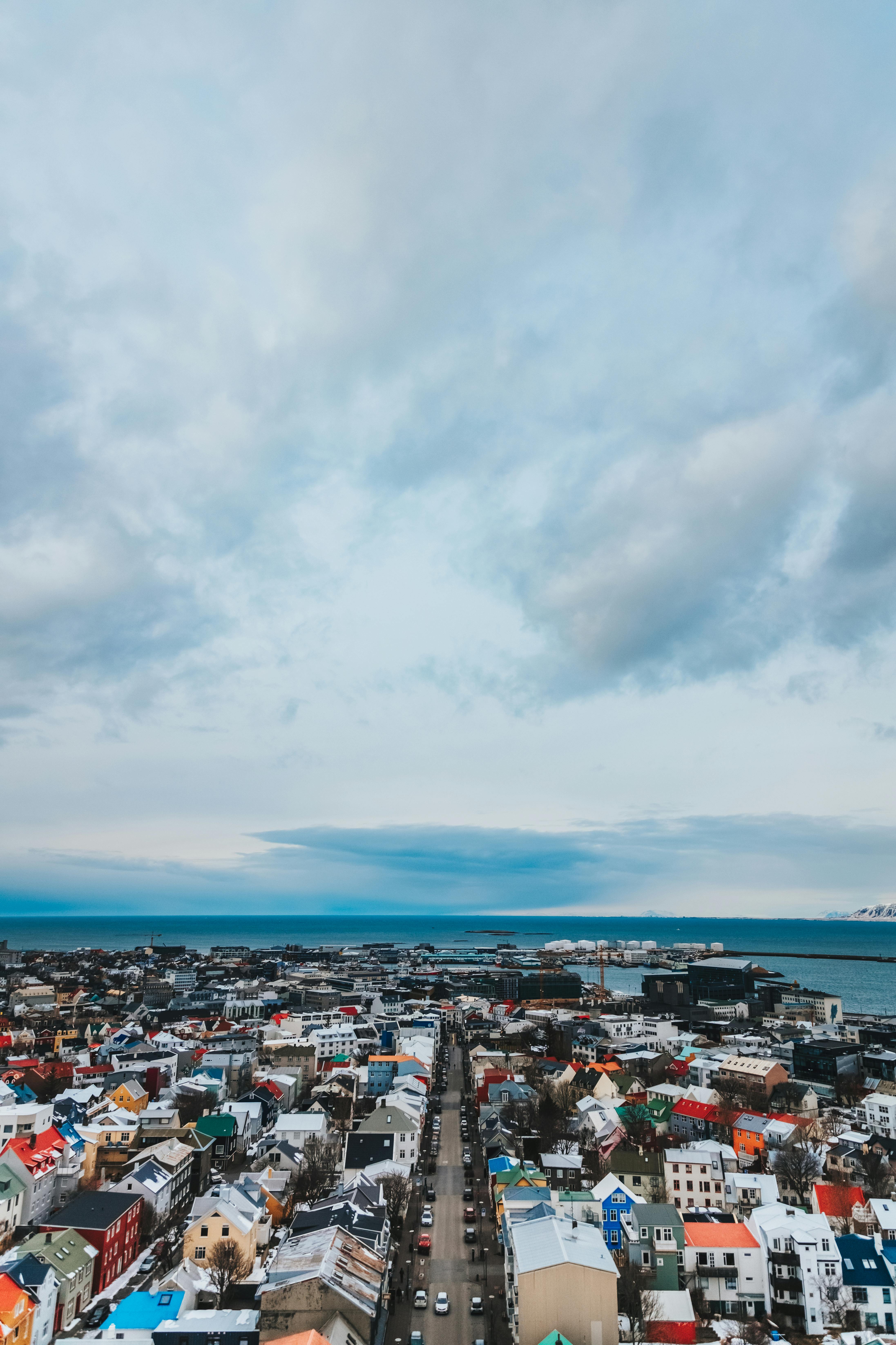 Cityscape with road near sea under cloudy sky · Free Stock Photo