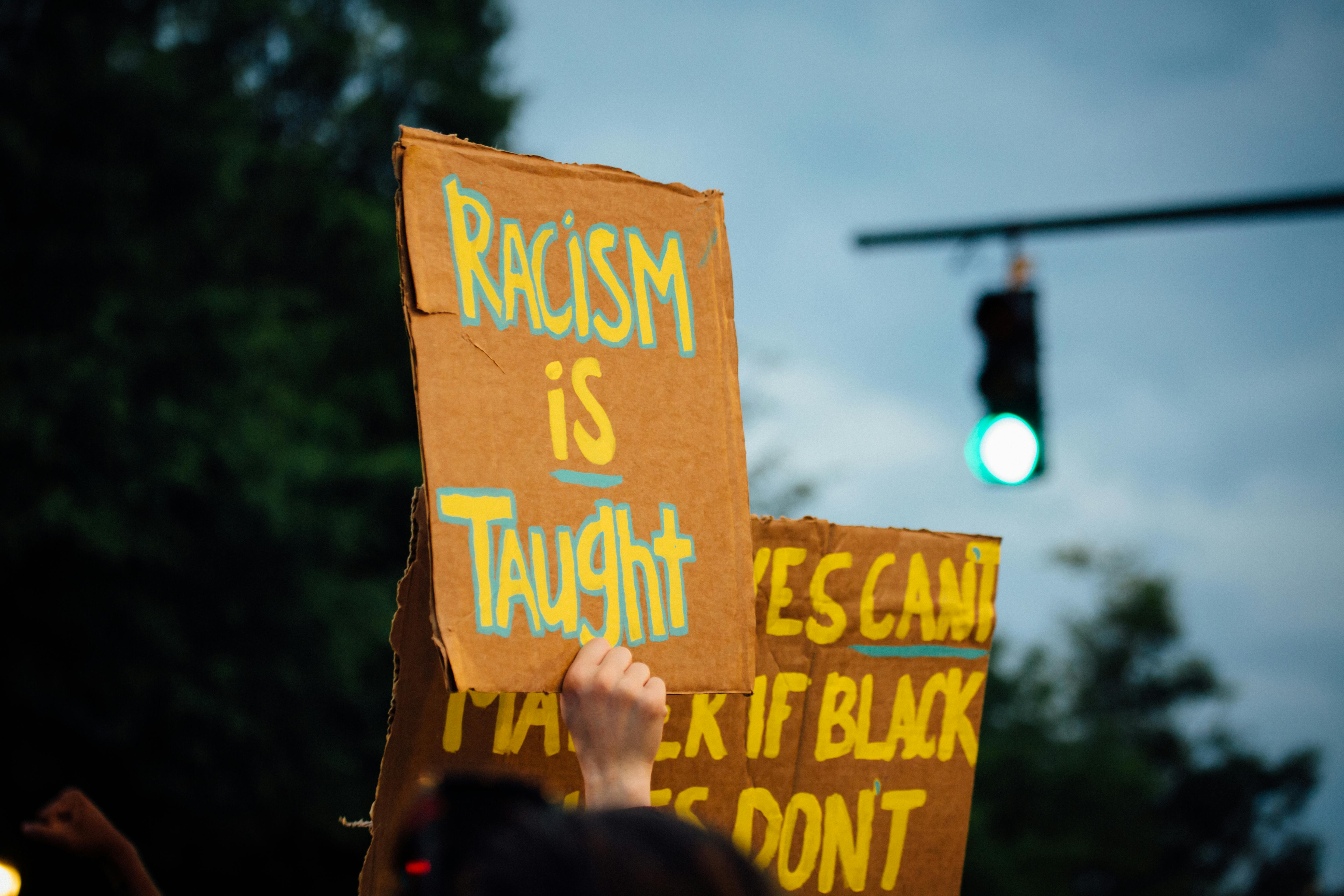Unrecognizable demonstrators showing anti racism placards during ...