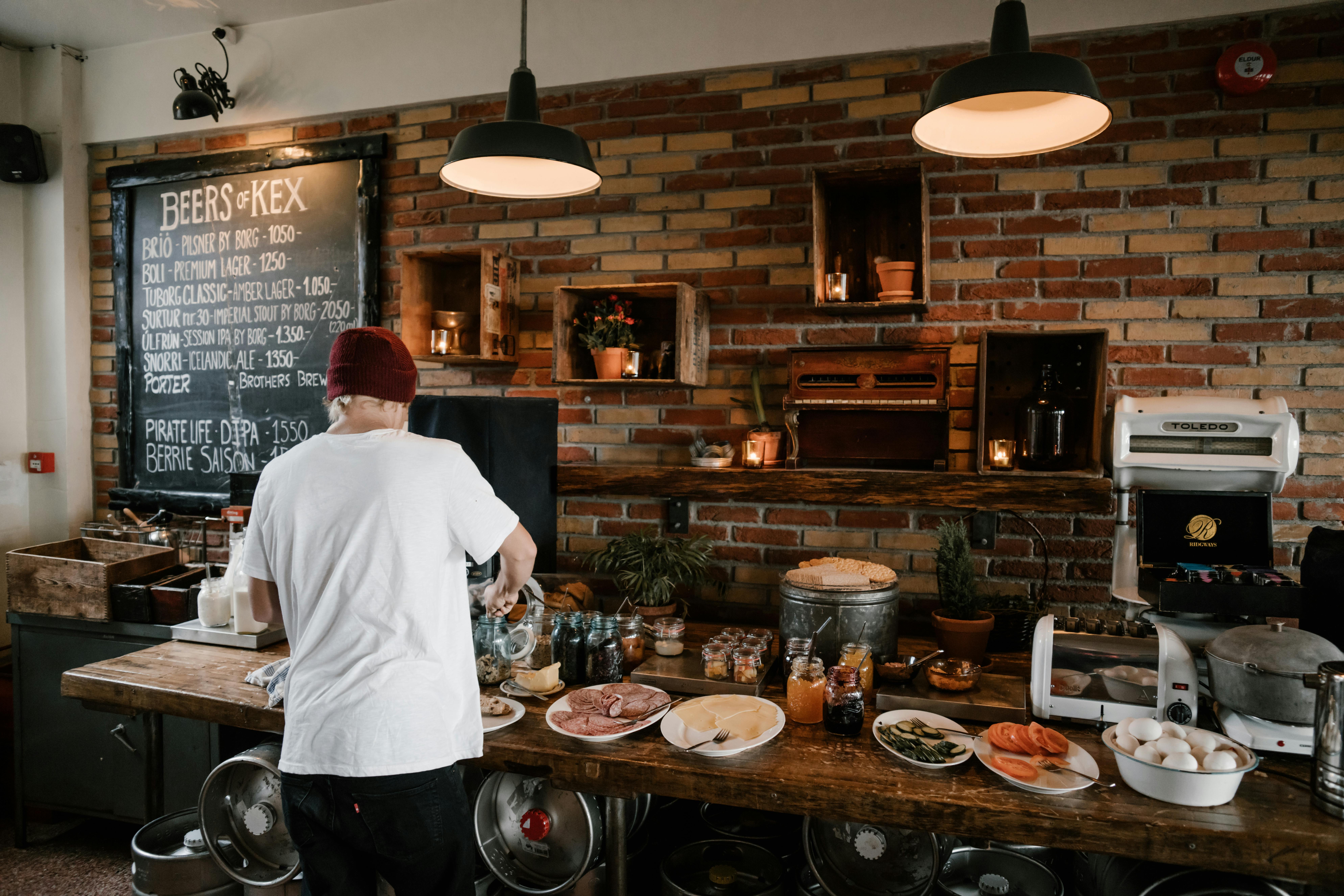 A Back View of a Person Getting Food from the Wooden Table · Free Stock ...