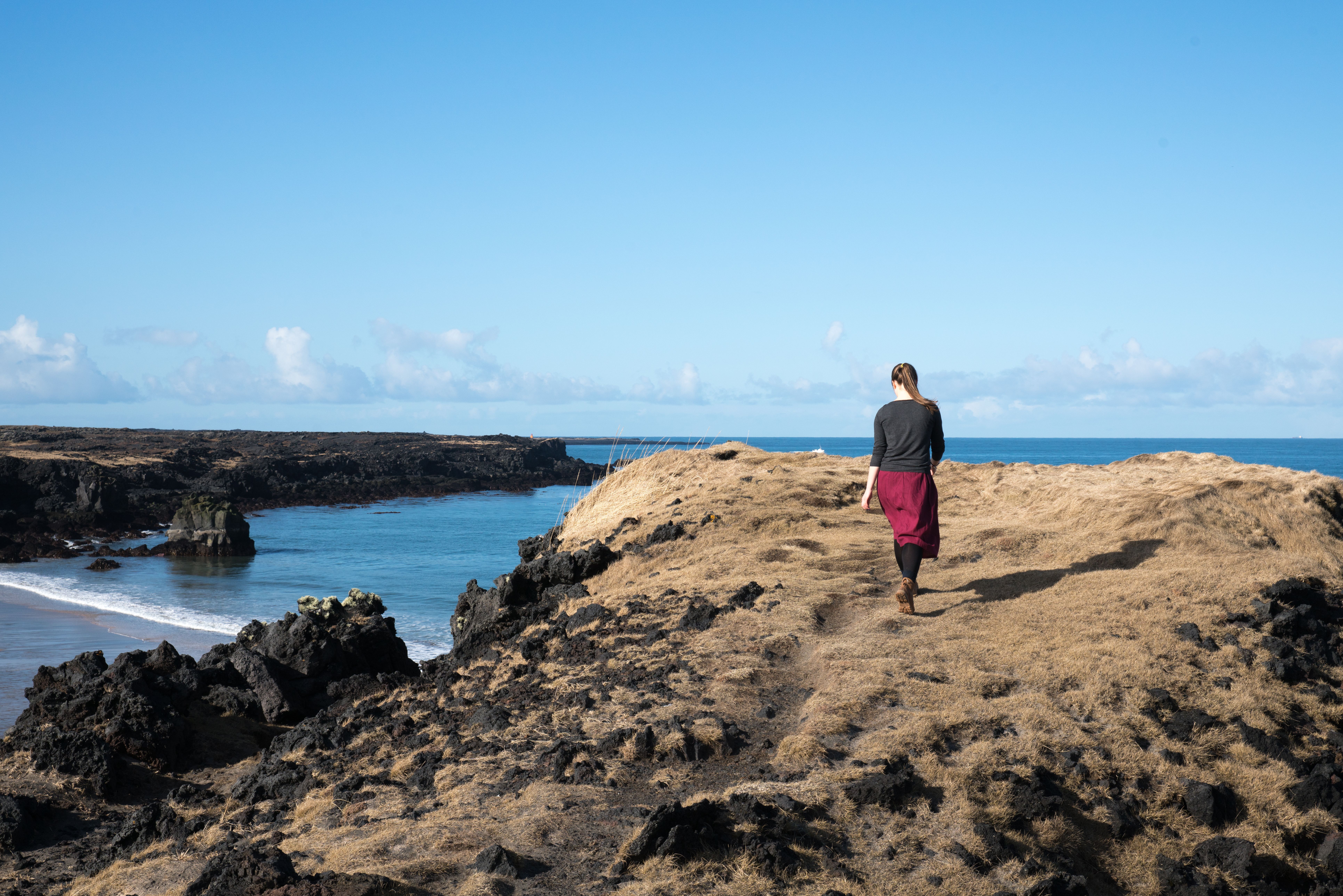 Woman Walking on a Seashore · Free Stock Photo