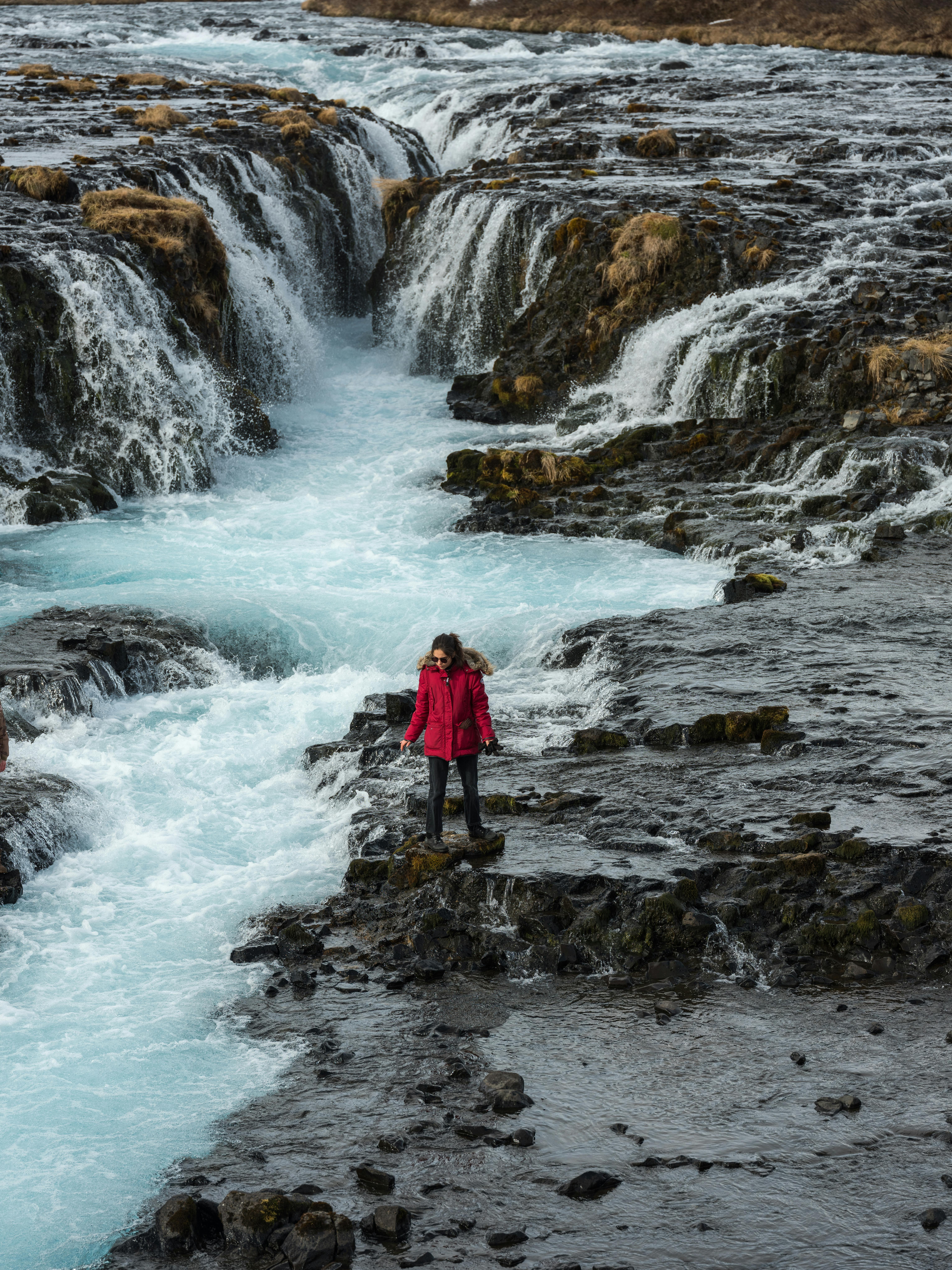 Person Standing under Flowing Water of Waterfall · Free Stock Photo
