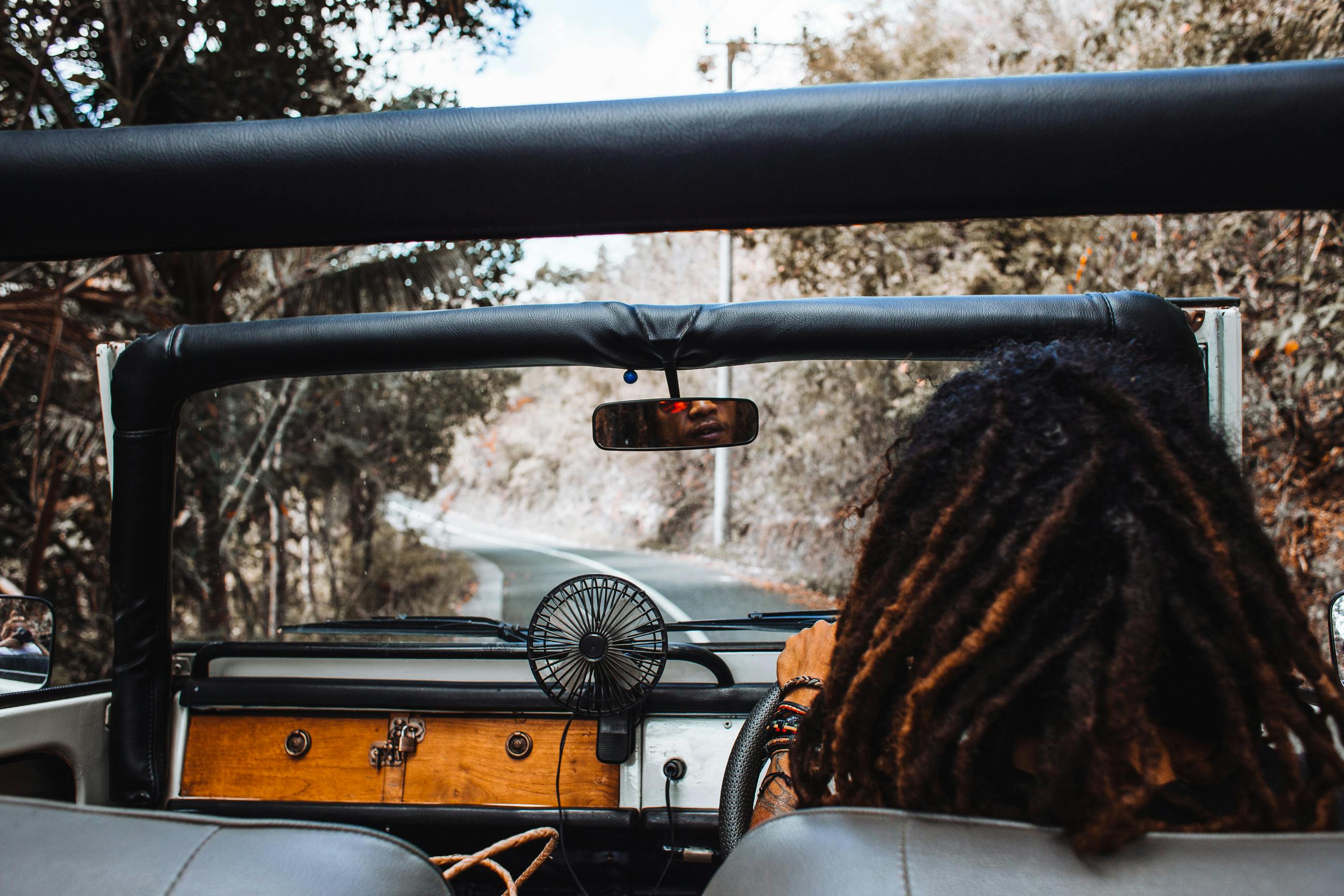 Faceless person driving car in daytime · Free Stock Photo