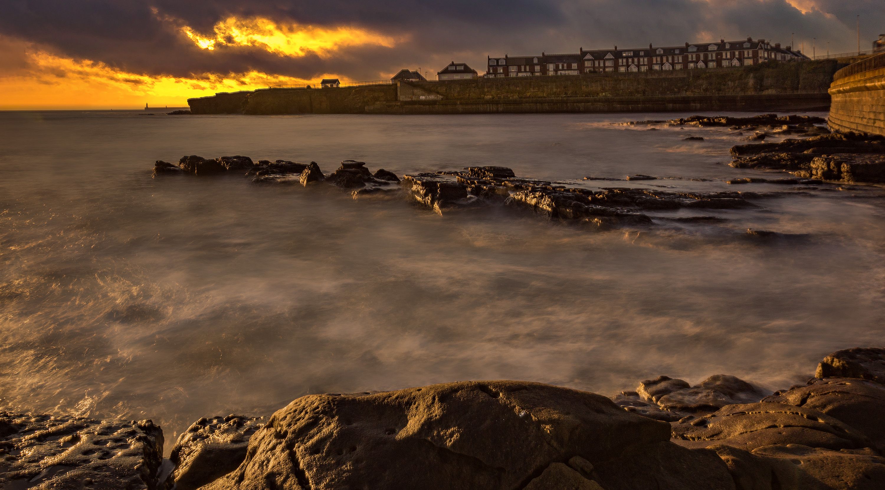 Wavy sea near stones in mist under bright sky · Free Stock Photo