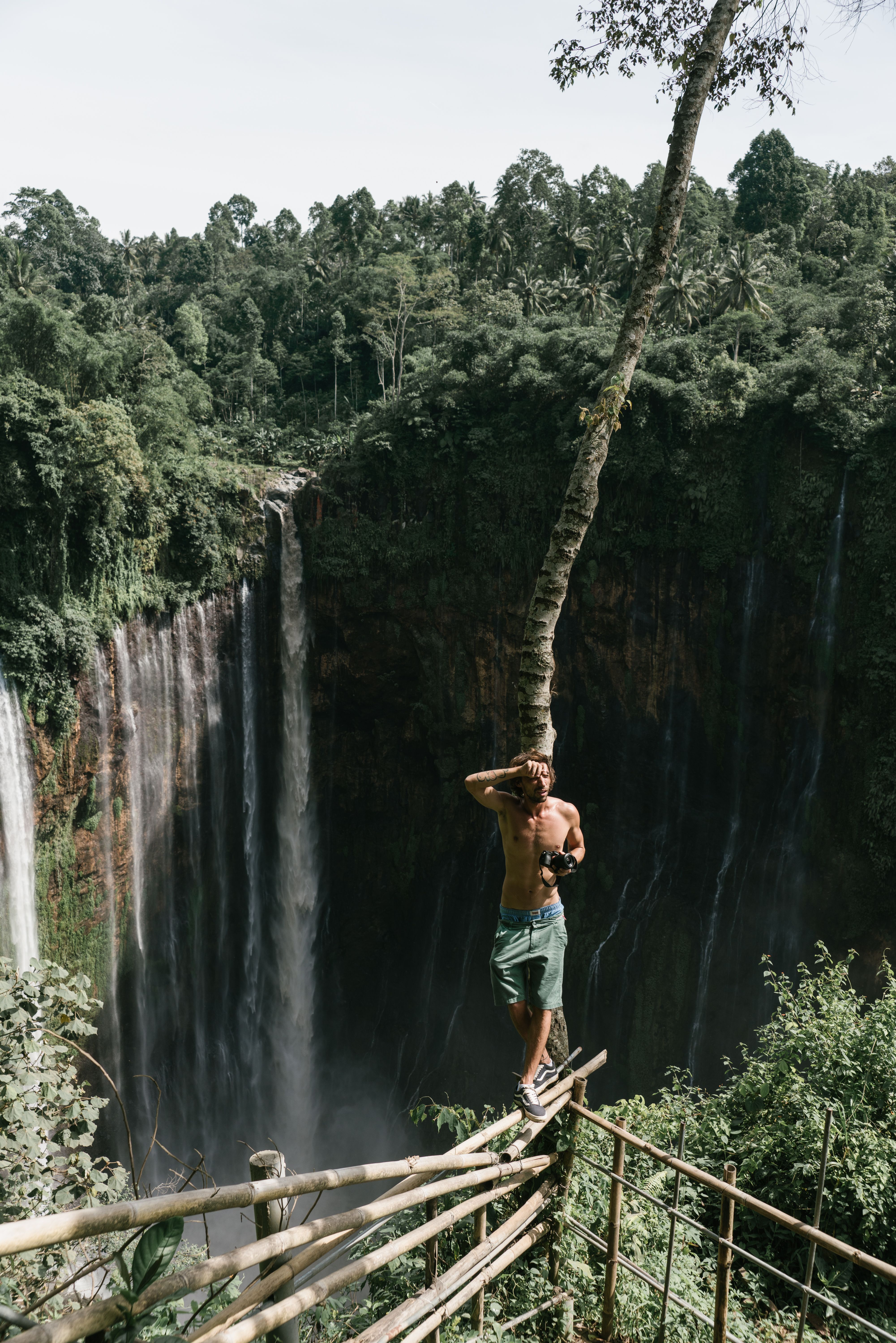 Man on Fence near Waterfalls · Free Stock Photo