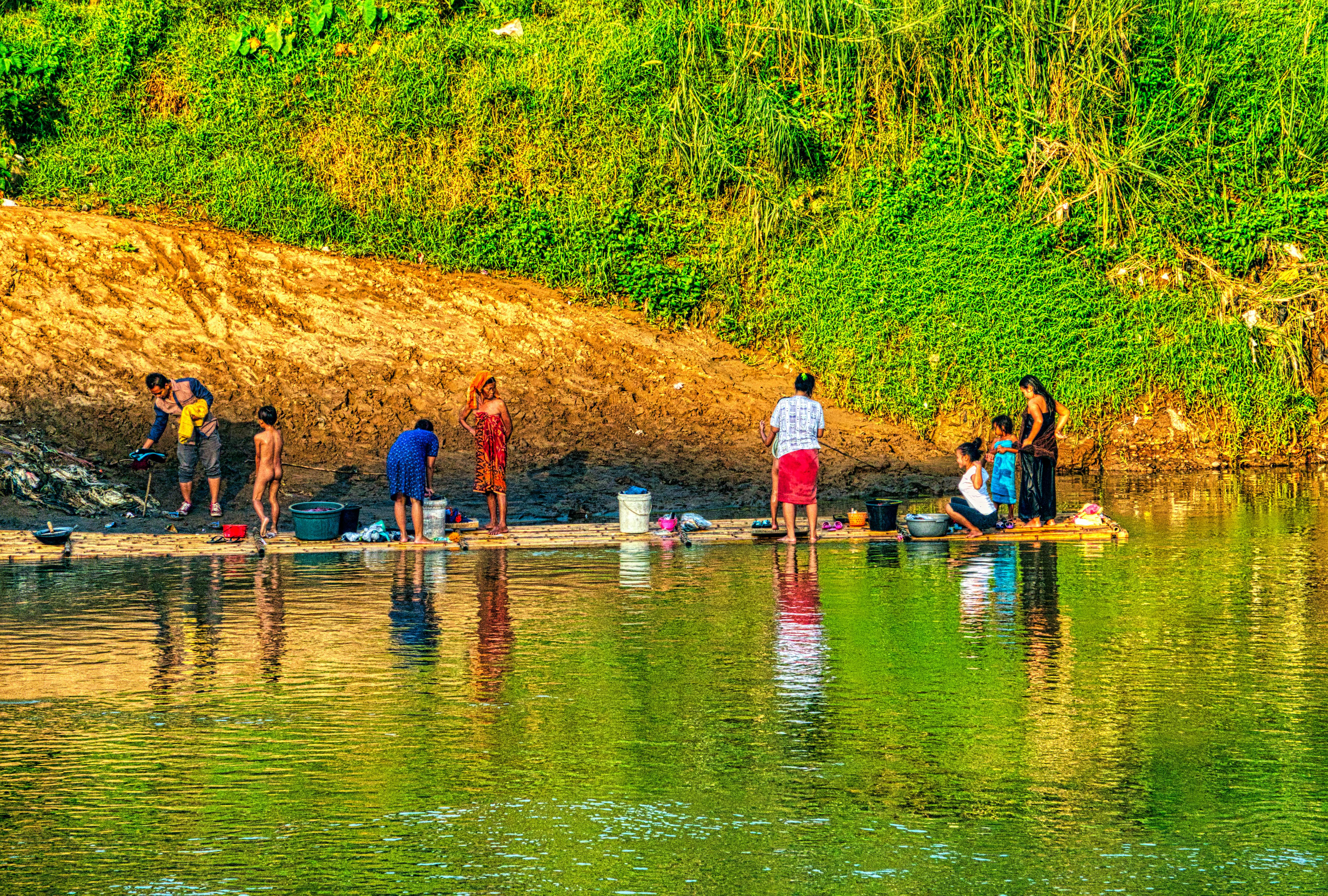 People Washing Clothes at a River Bank · Free Stock Photo