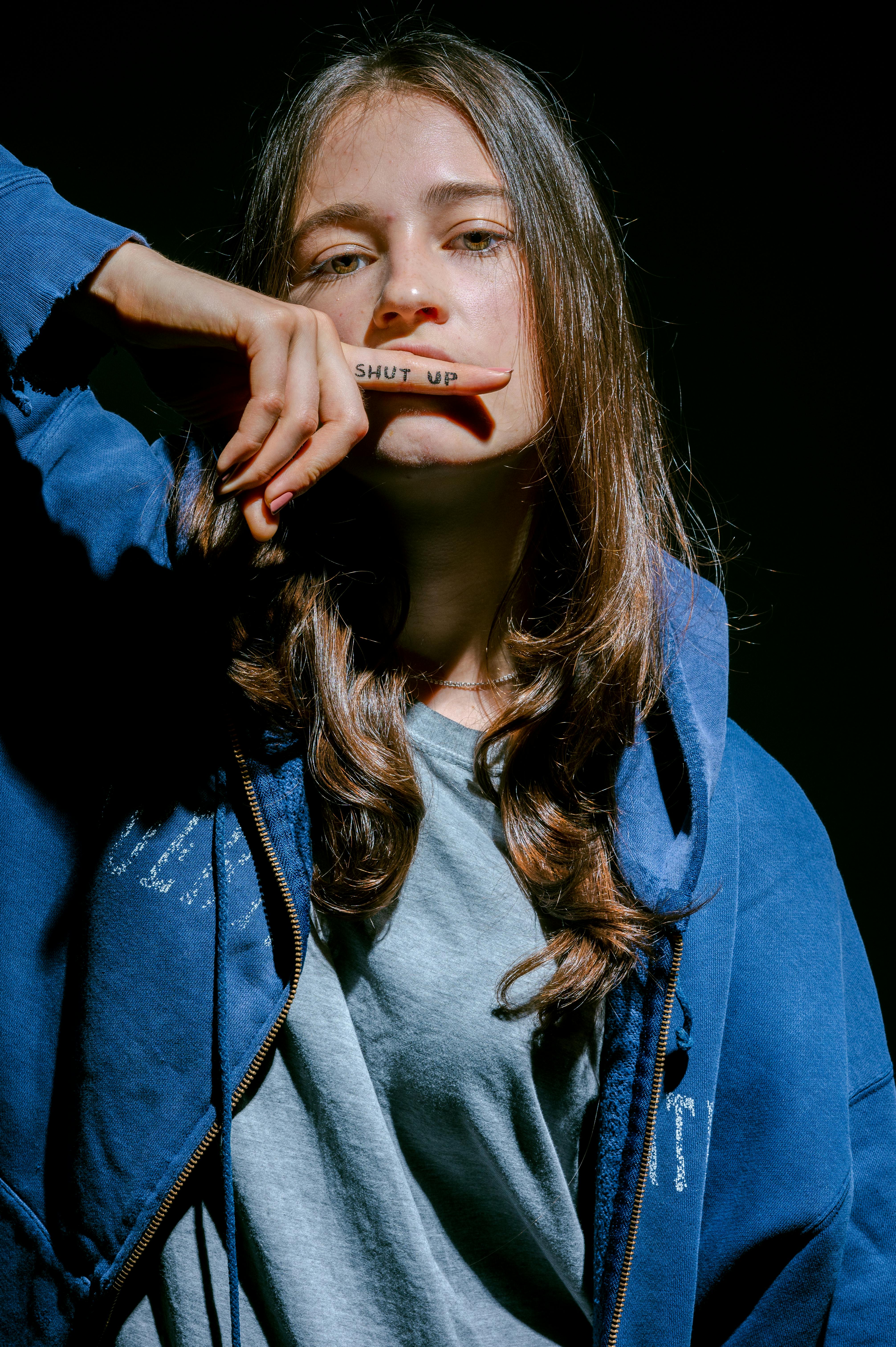 A Young Woman Biting Her Index Finger with a Shut Up Note · Free Stock ...