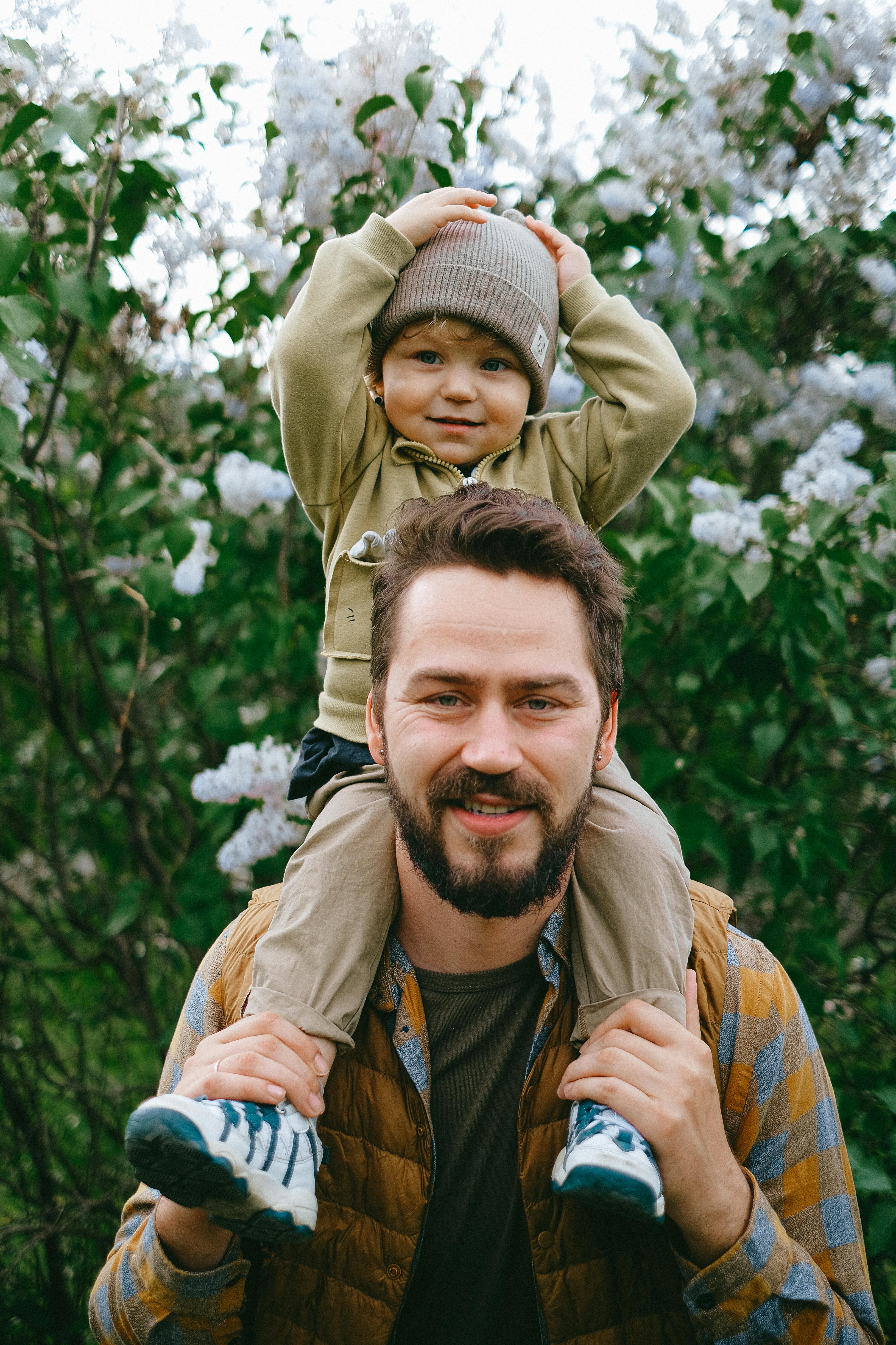 Father in Mustard Winter Jacket Carrying a Cute Toddler Boy in Gray ...