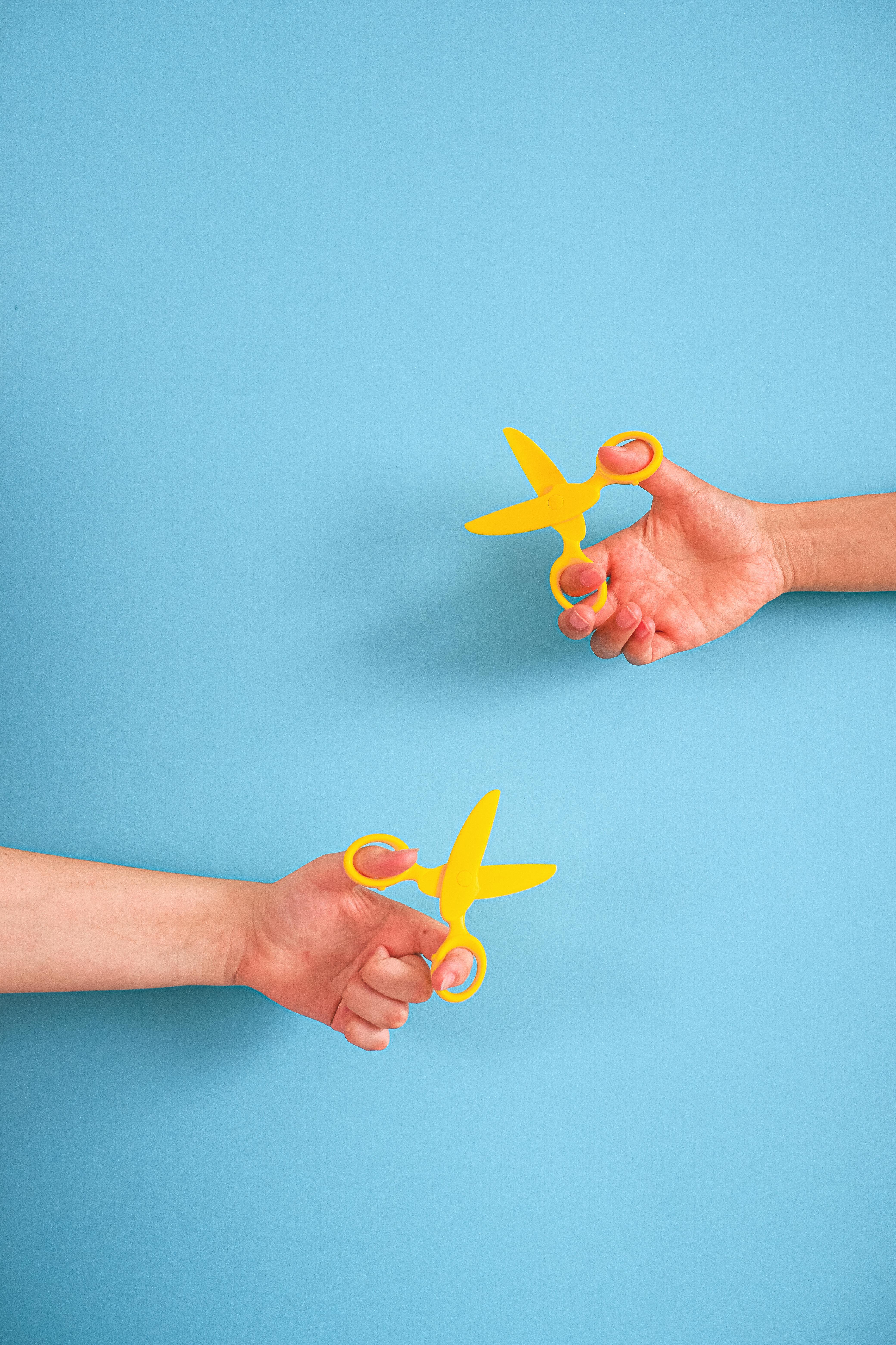 People Holding Yellow Toy Scissors · Free Stock Photo