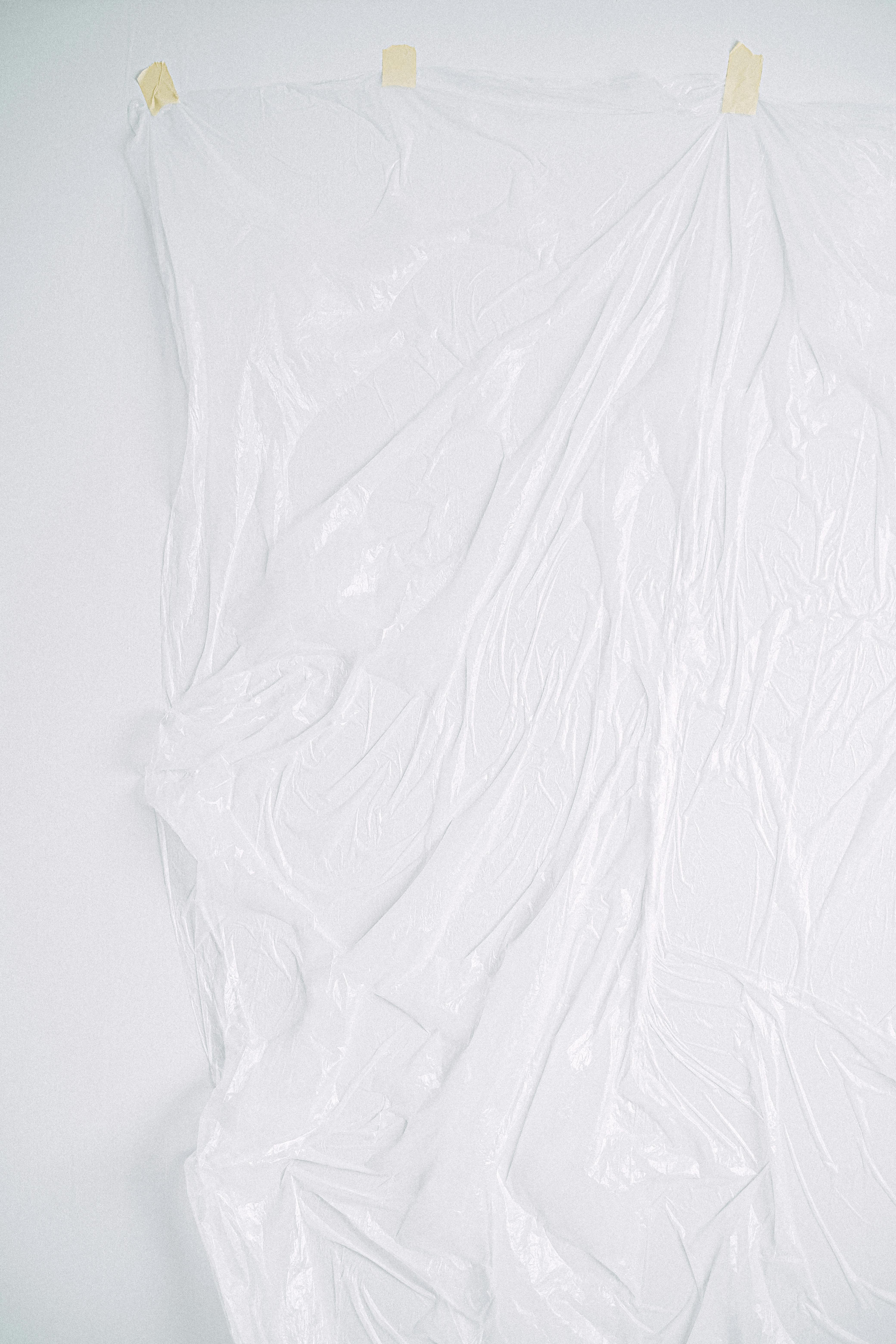 Photo of a Clear Plastic Taped on a White Surface · Free Stock Photo