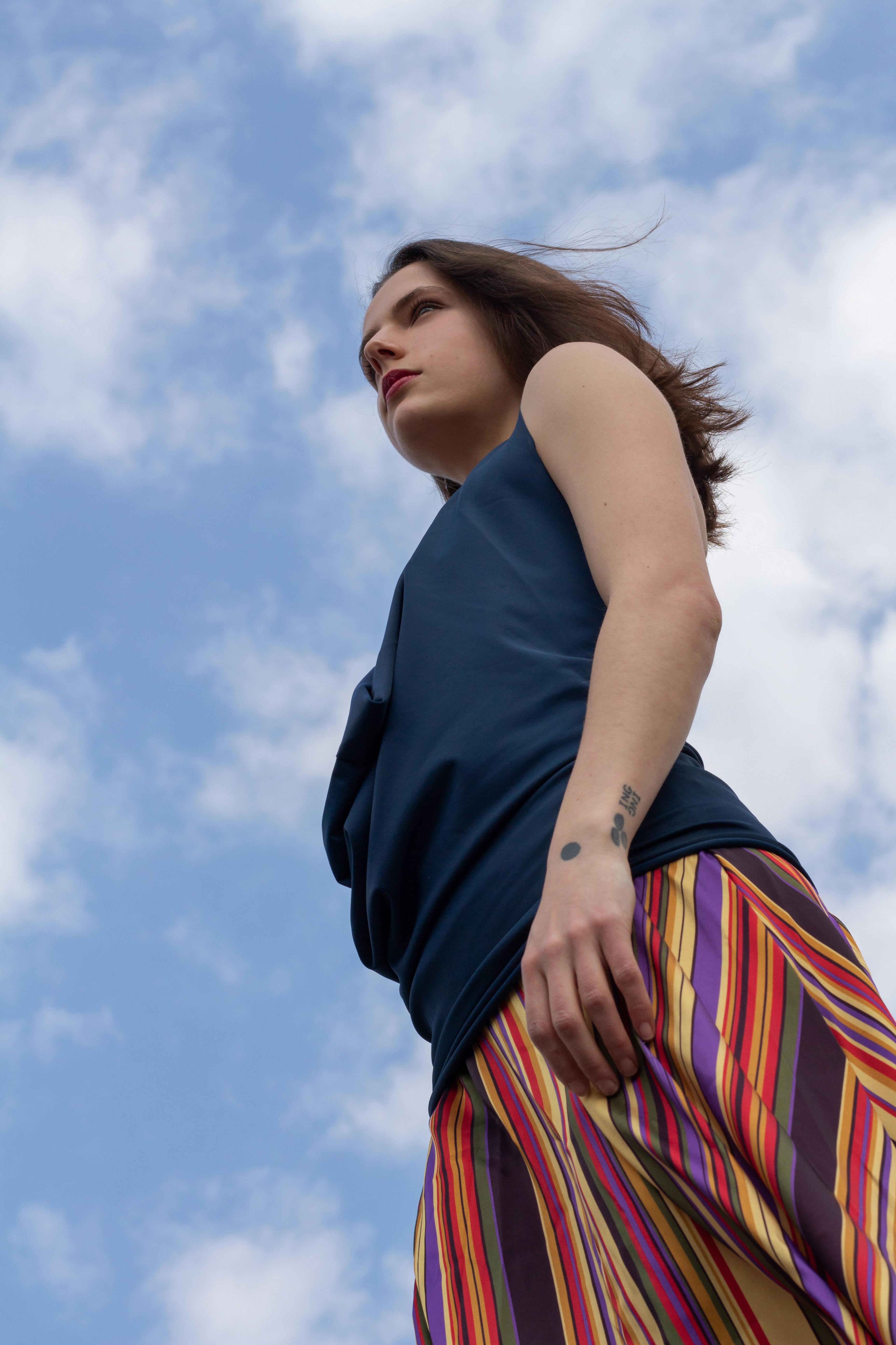 Low Angle View Portrait of Woman Against a Cloudy Sky · Free Stock Photo