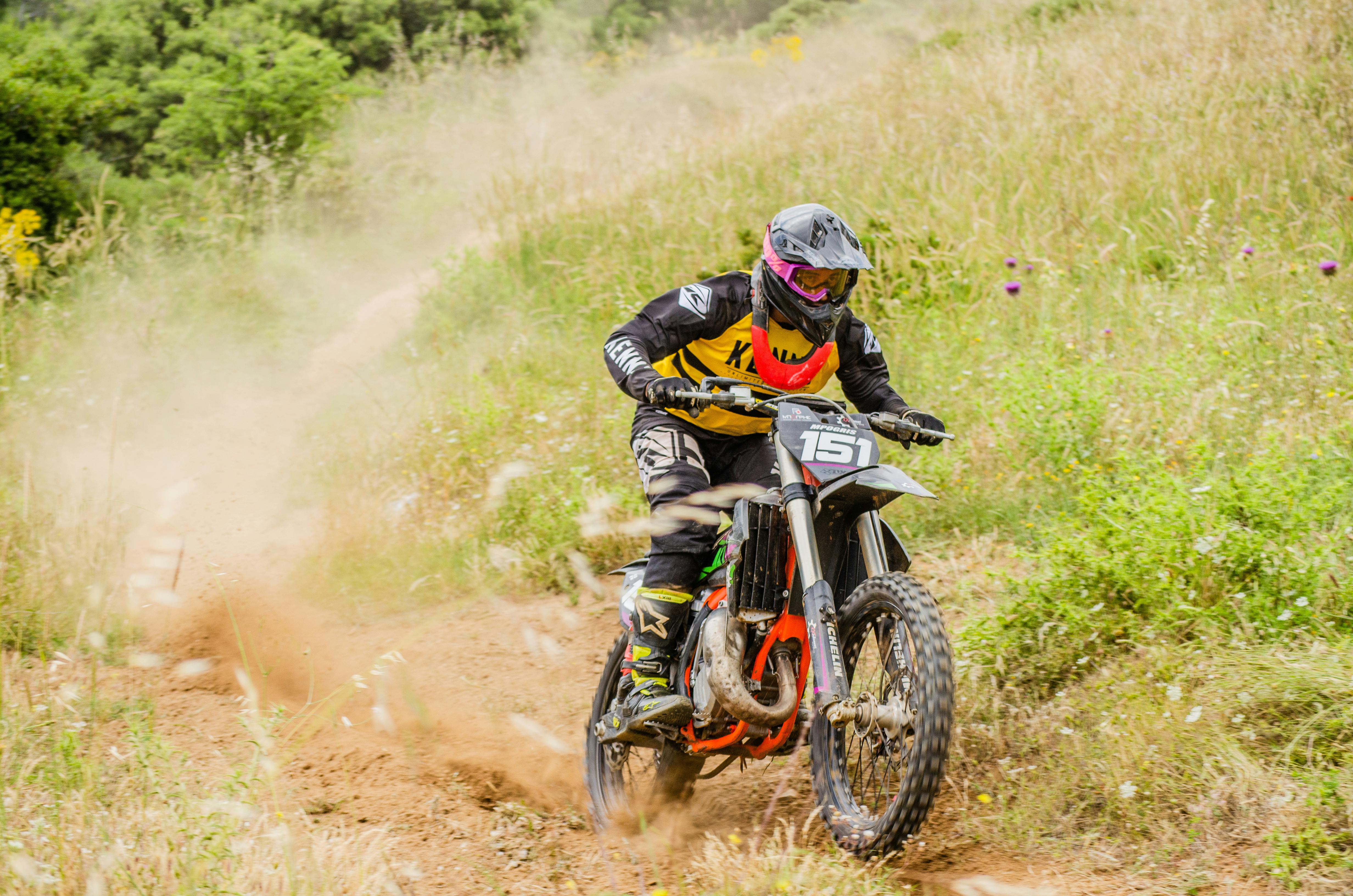 Faceless biker riding motorcycle in park amidst green trees · Free ...