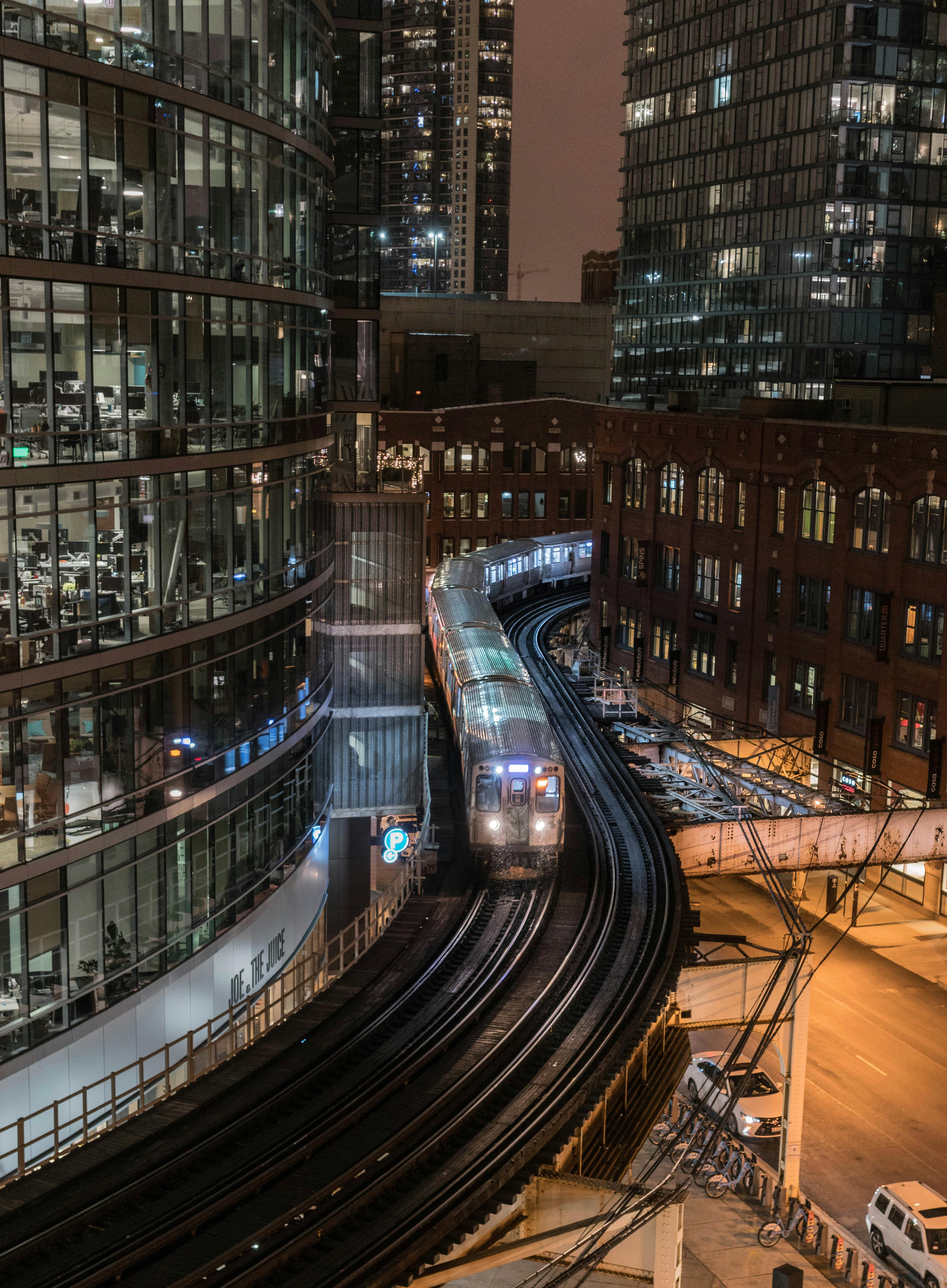 Train on Railroad Between Buildings · Free Stock Photo