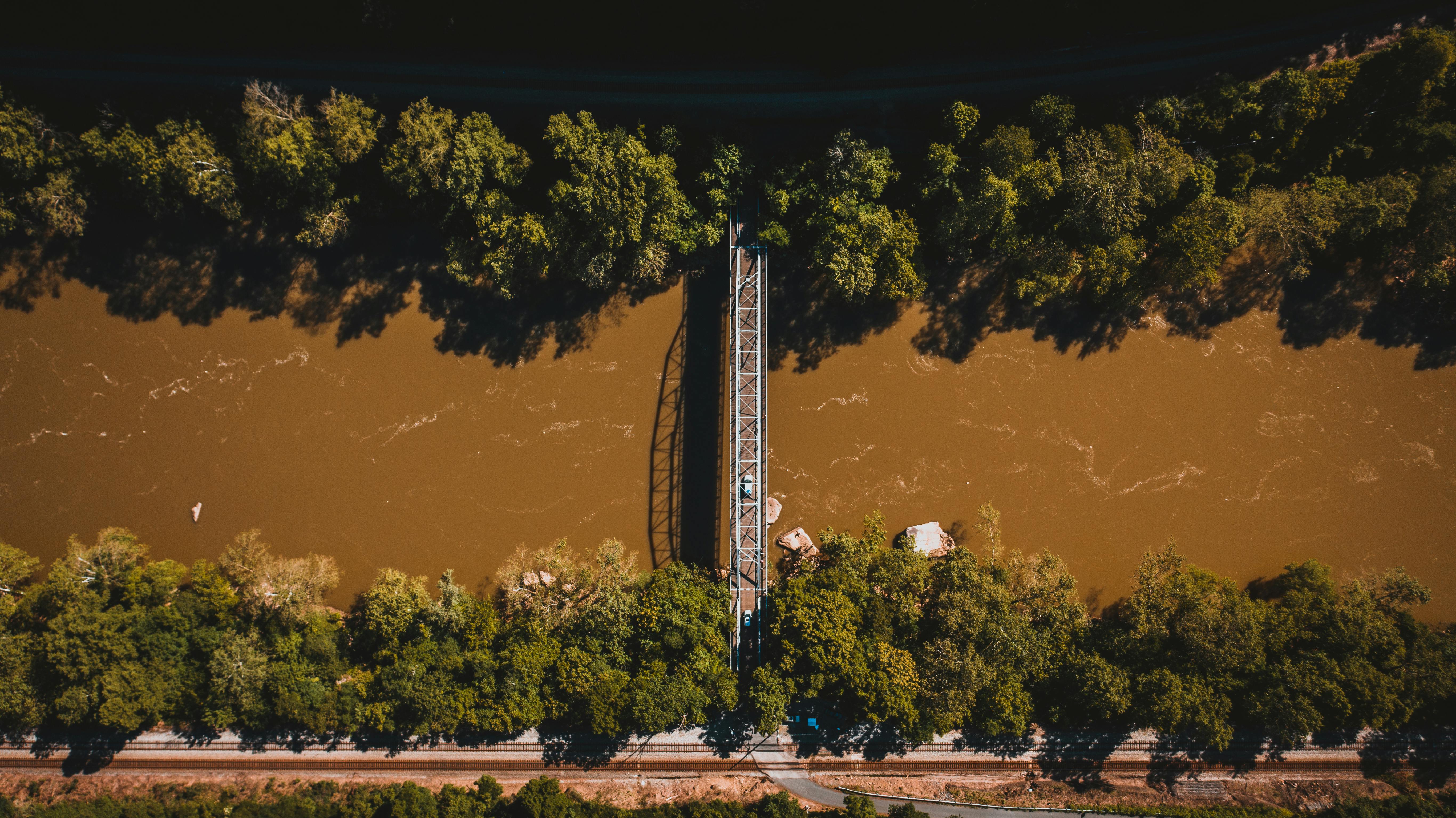 Bridge over wild river in suburb · Free Stock Photo