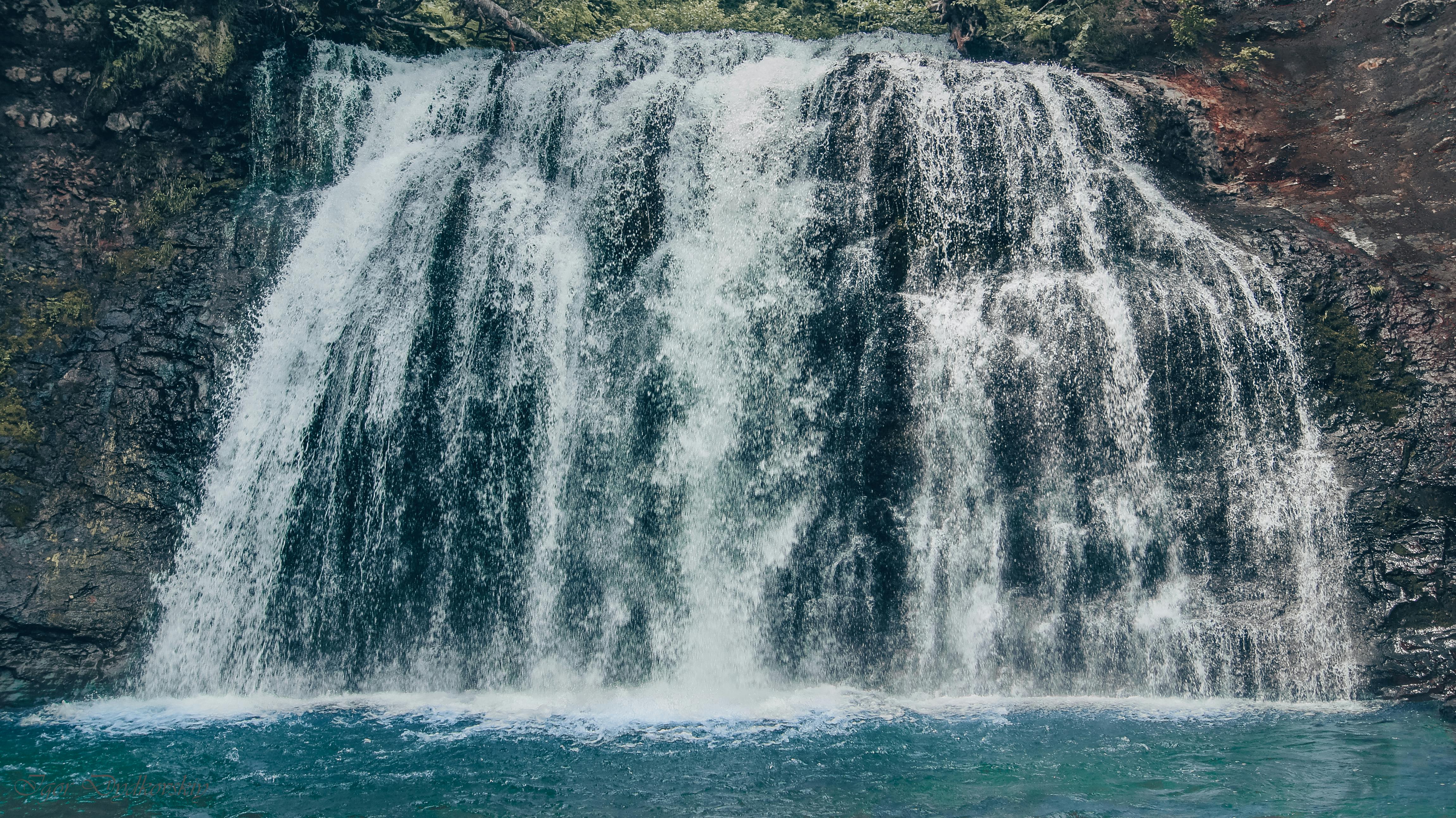 Fast waterfall in mountains near rippled river · Free Stock Photo