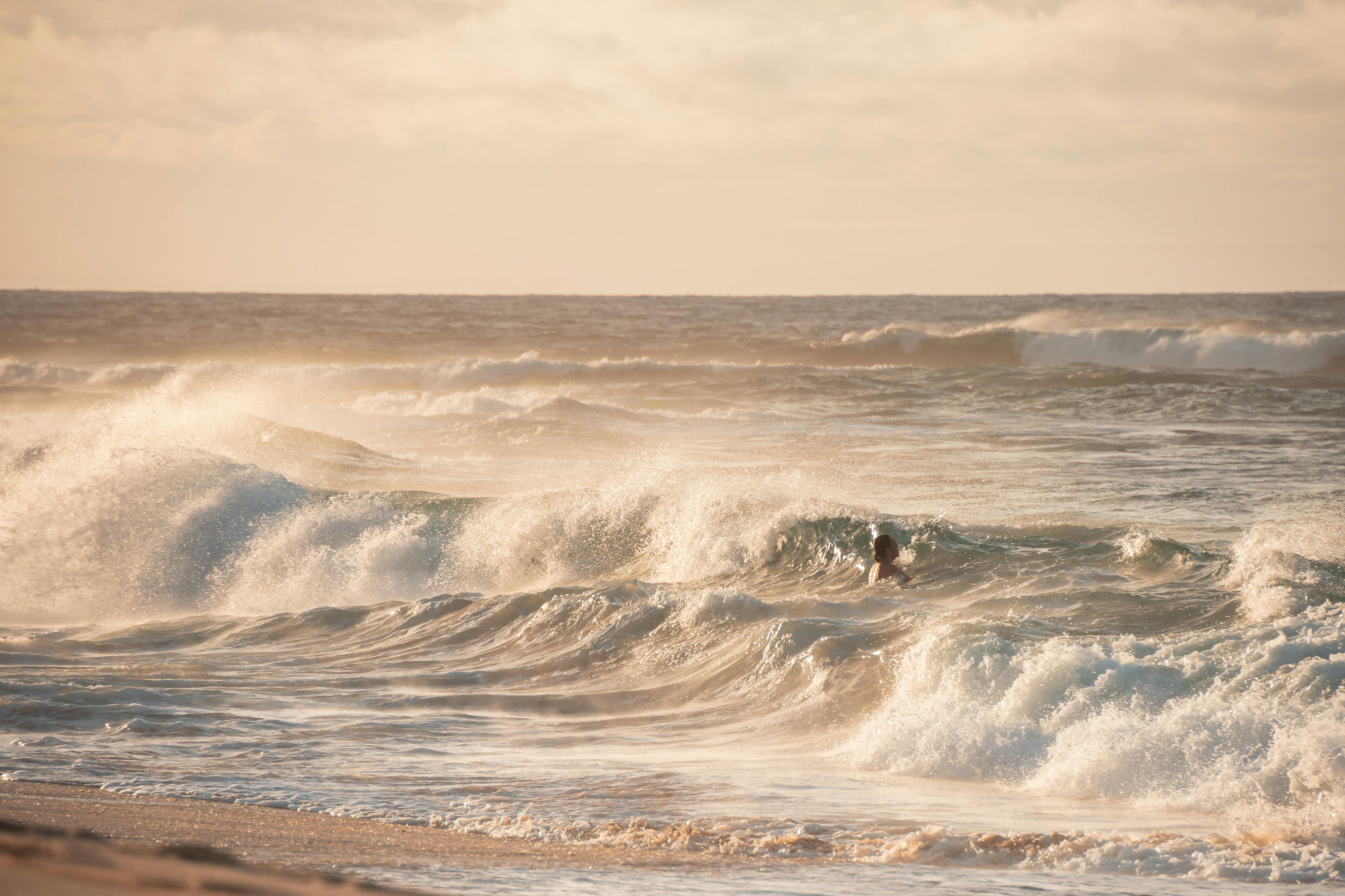 Person Swimming on Ocean Waves Crashing on Shore · Free Stock Photo