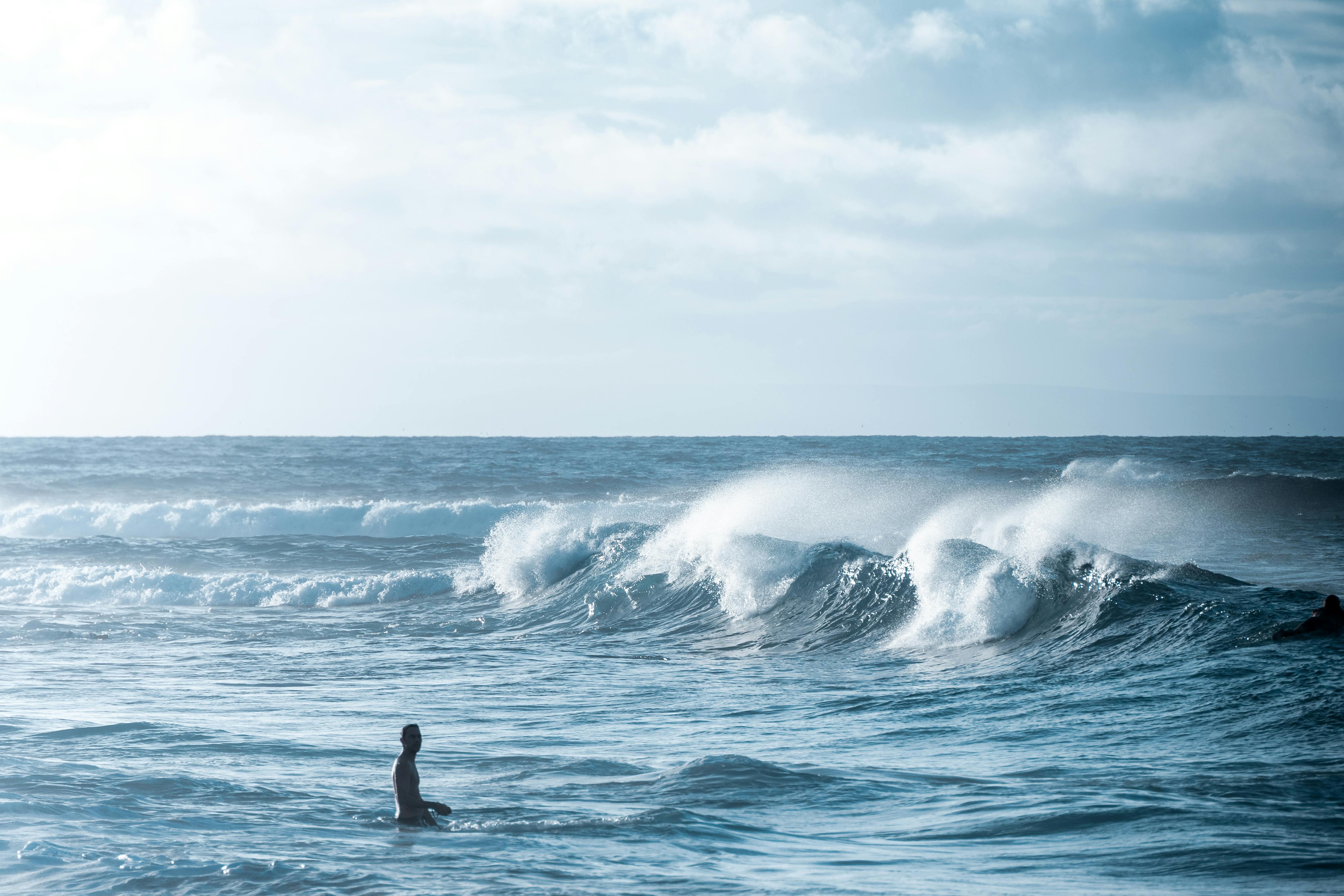 Person Standing on Ocean Waves · Free Stock Photo