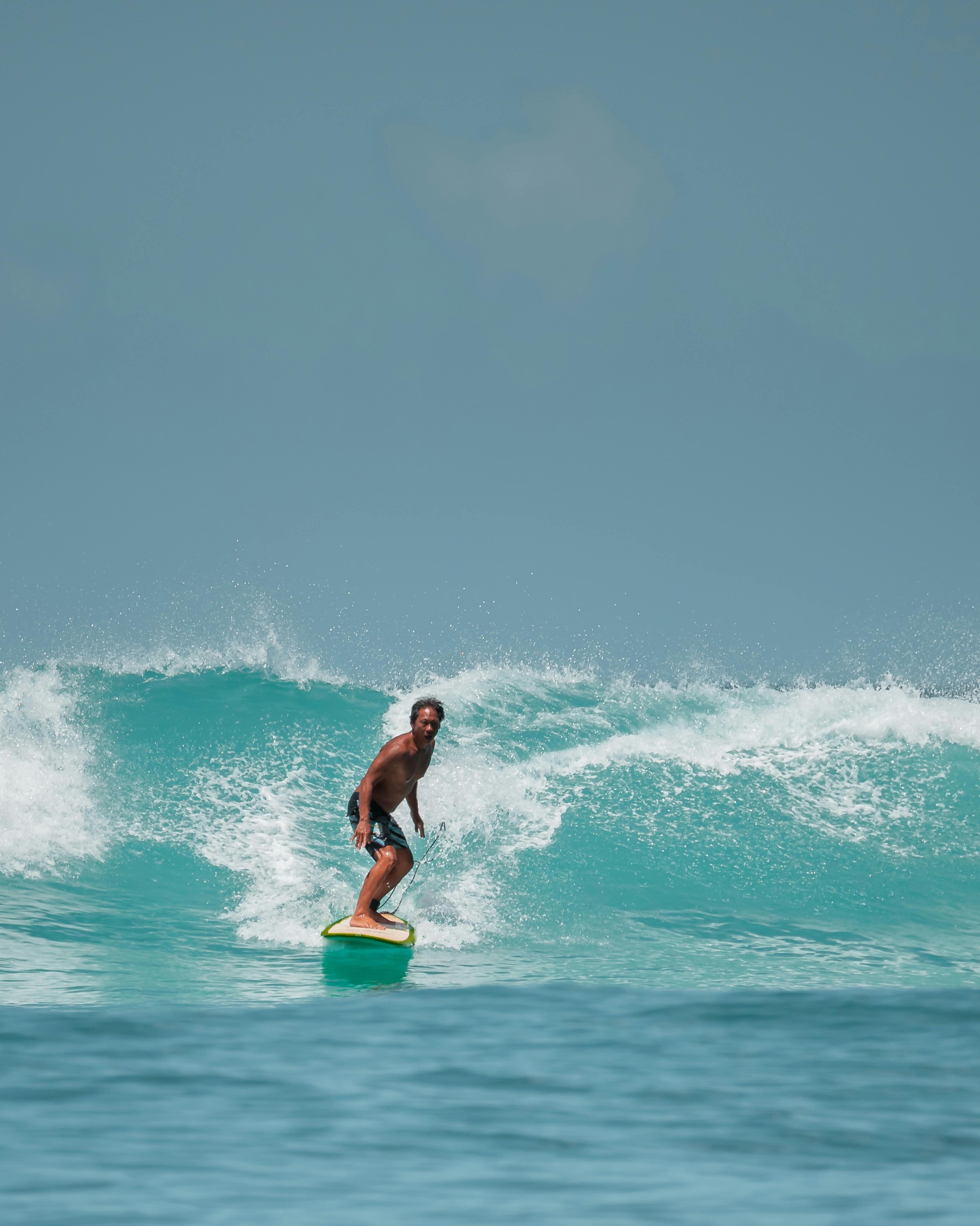 Woman in Red Bikini on Green Surfboard on Sea Waves · Free Stock Photo