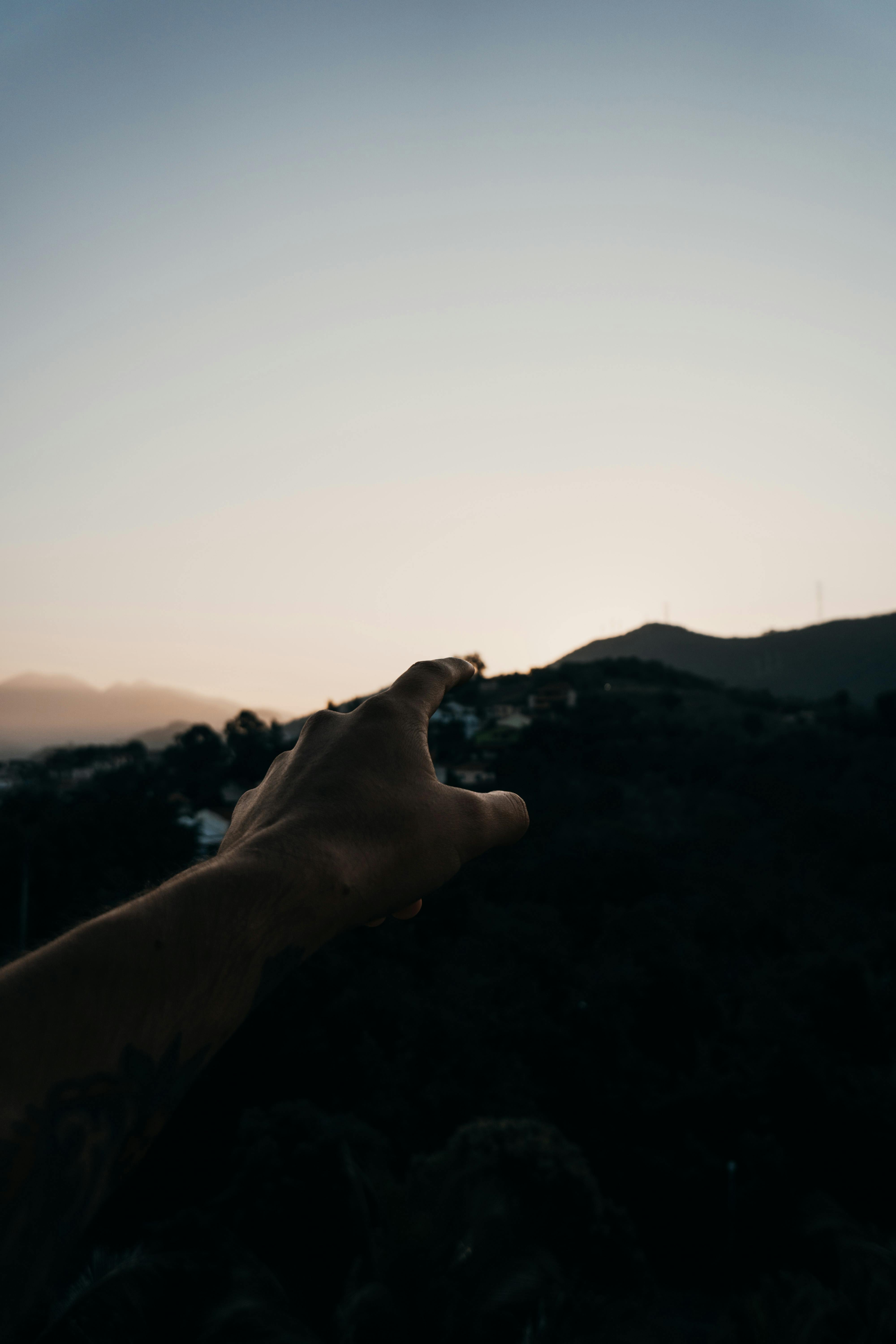 Crop hiker with outstretched hand against mountains at sundown · Free ...