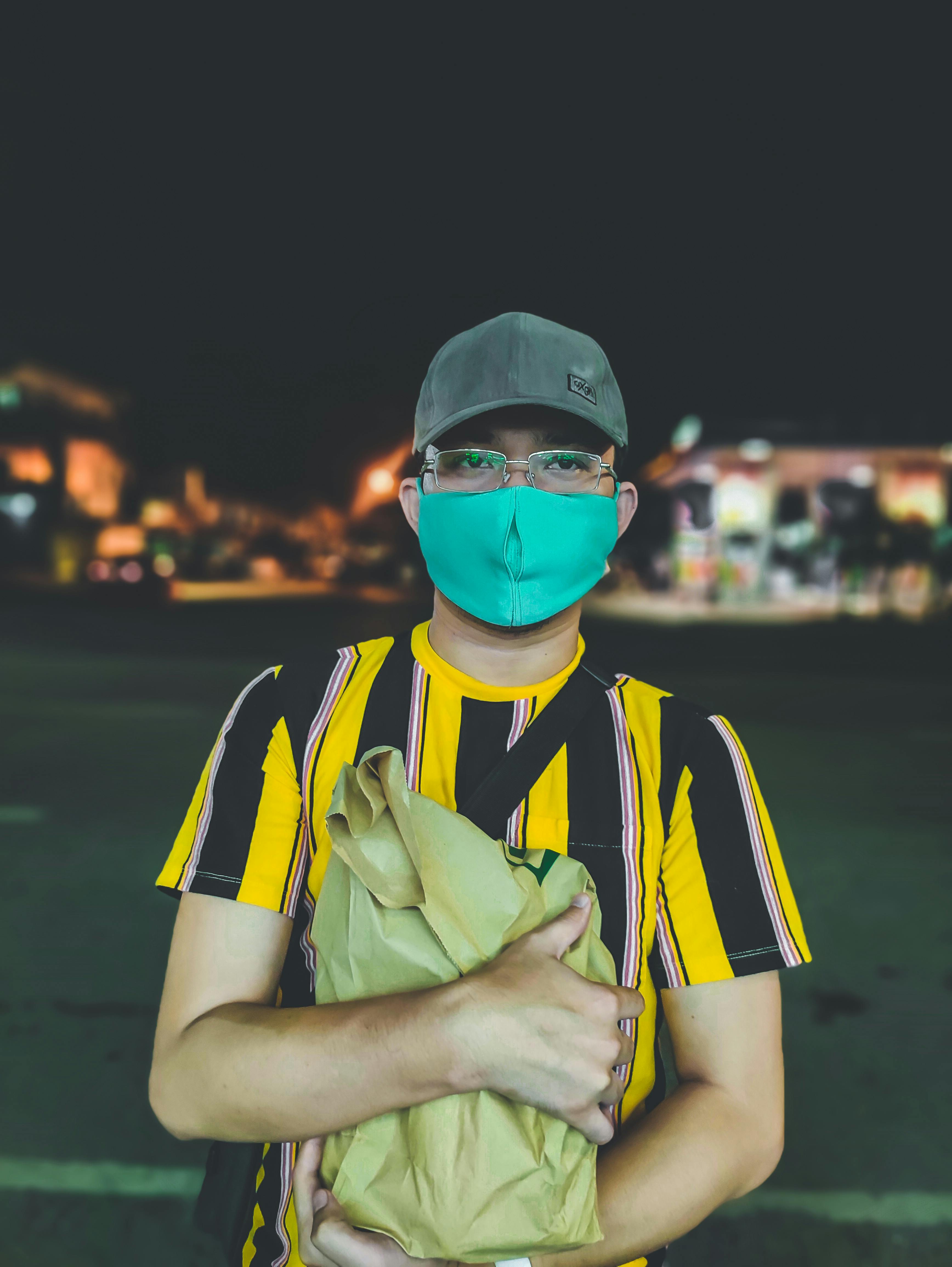 Person Holding Paper Bag and Face Mask · Free Stock Photo