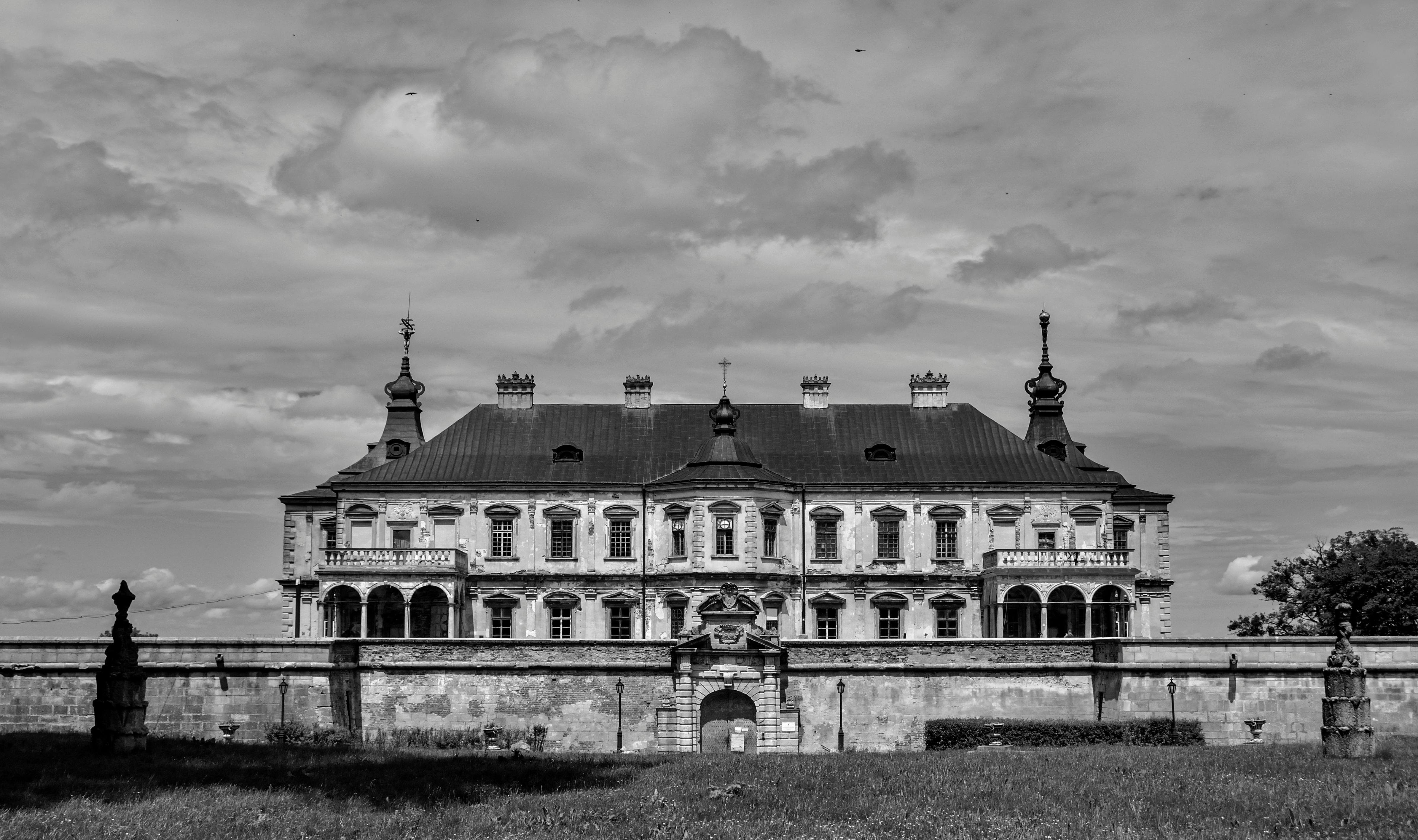 Old castle facade near stone fortress under sky · Free Stock Photo