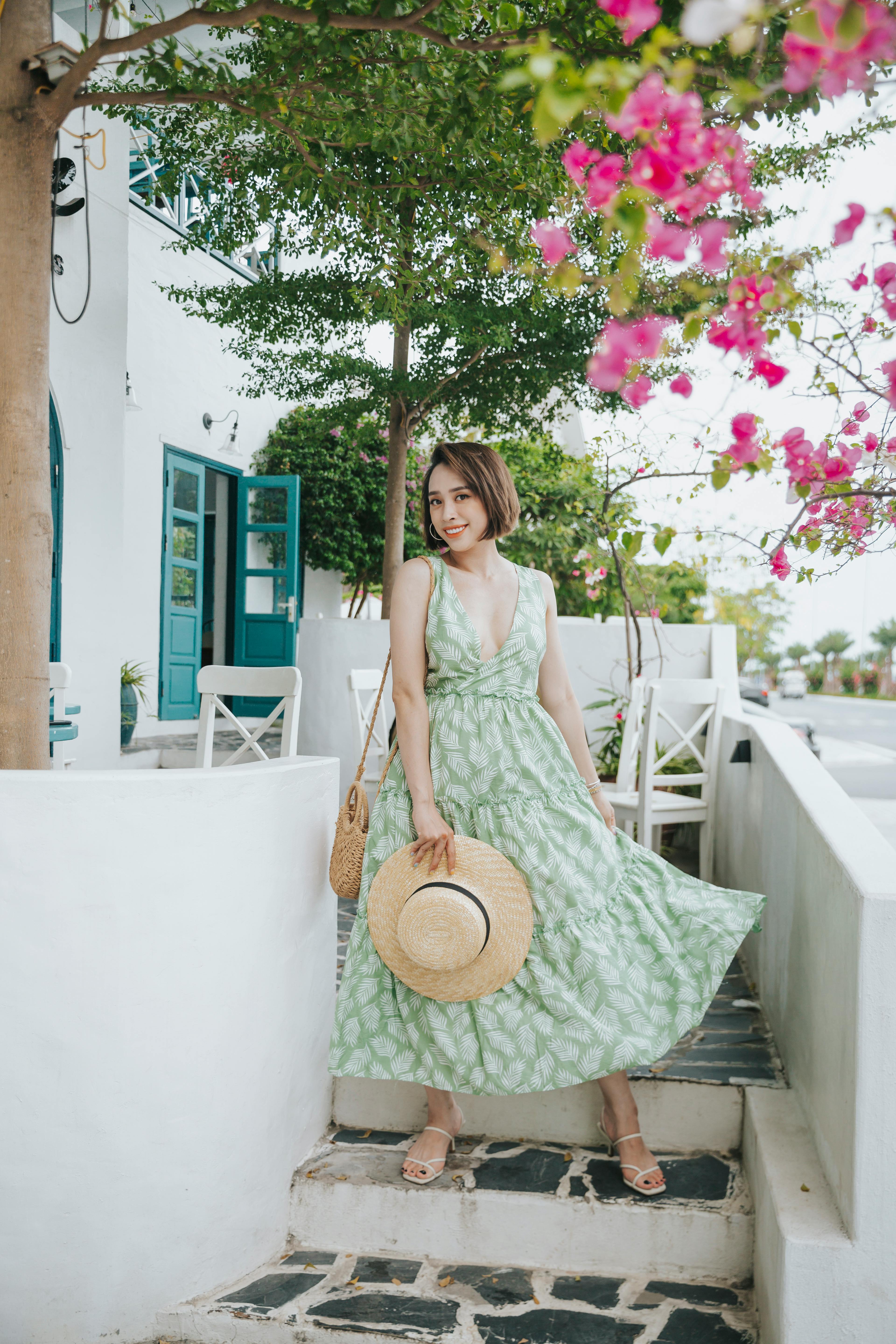 Positive ethnic woman in modern sundress with hat on stairs · Free ...