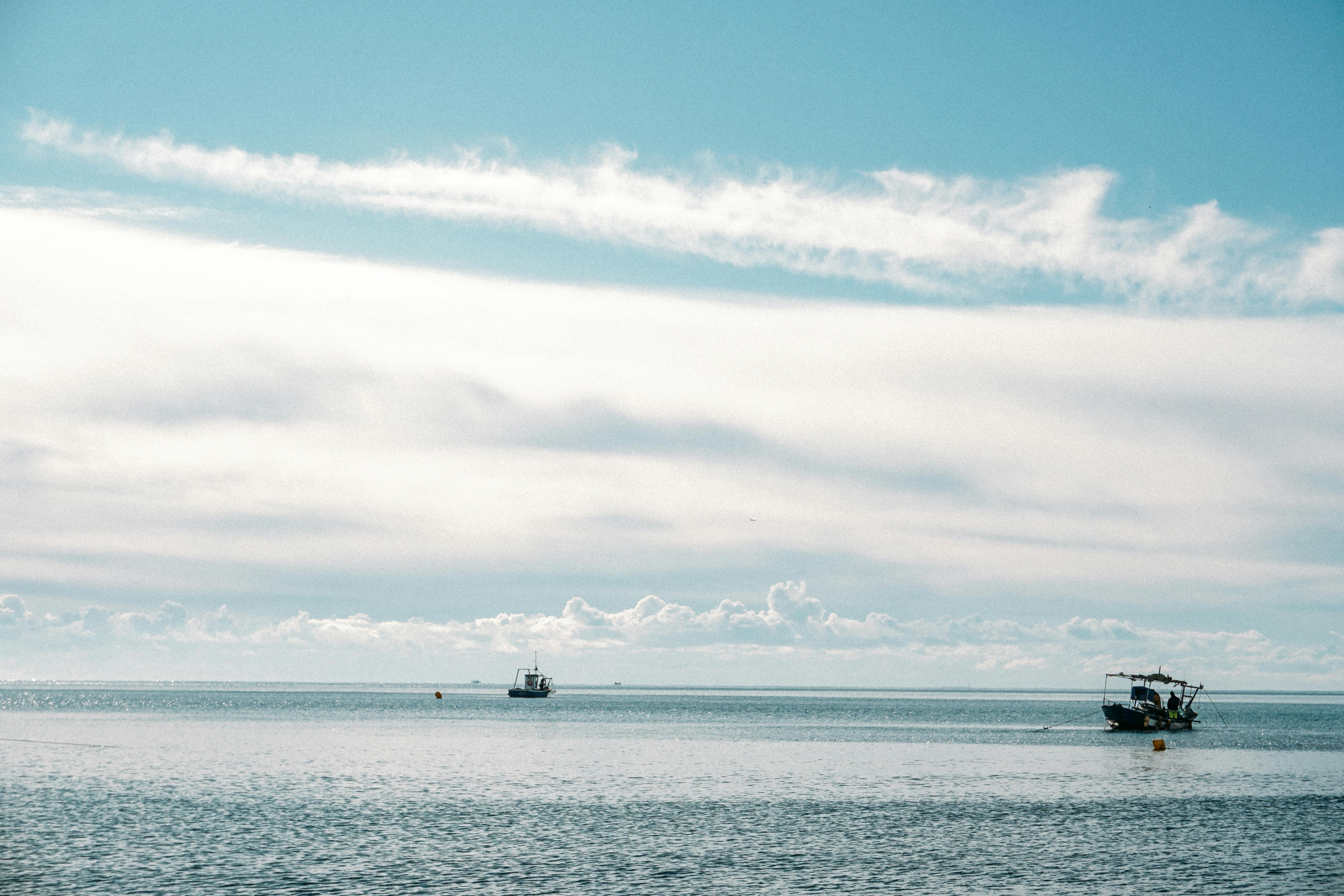 Boats floating on calm blue water · Free Stock Photo