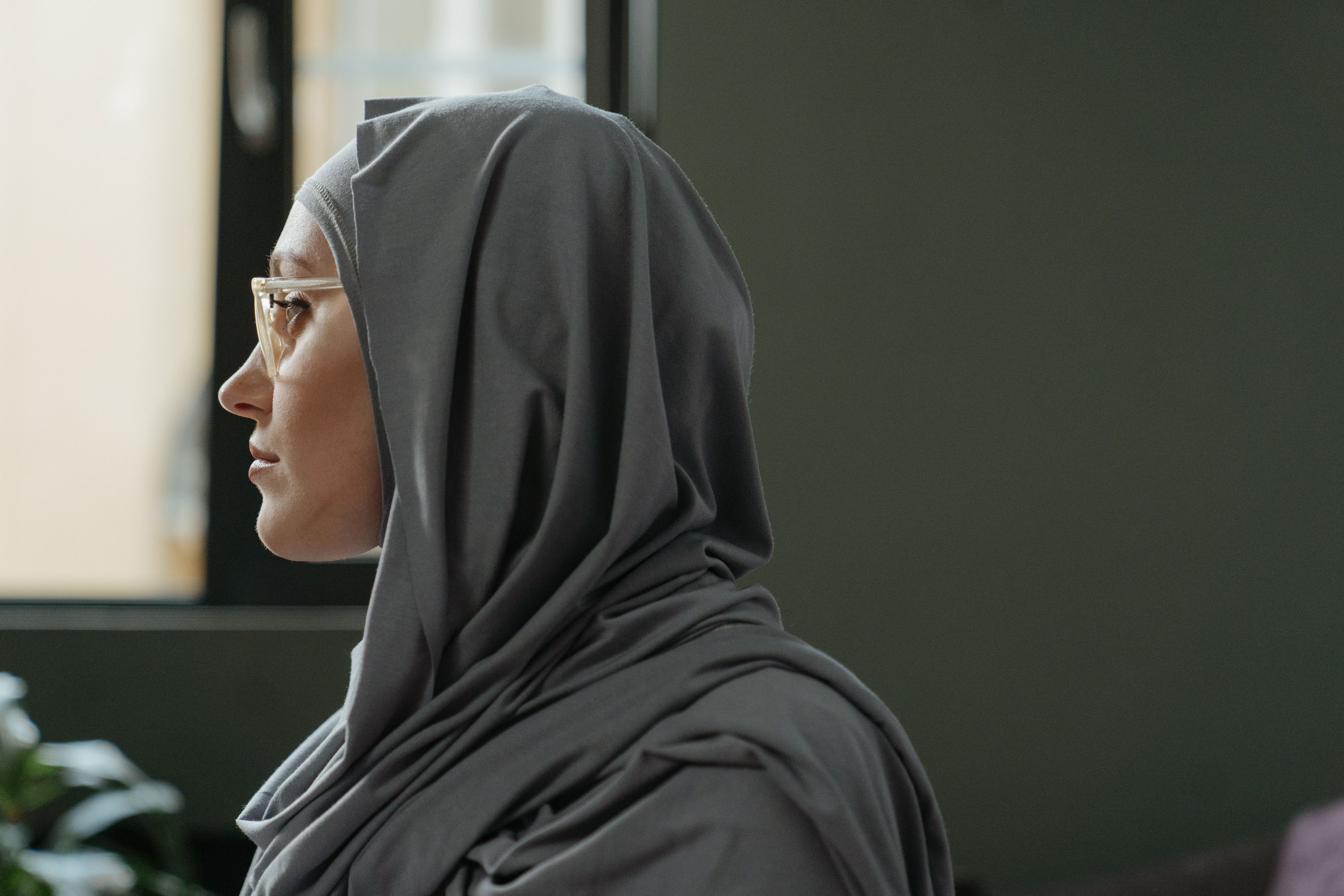 Woman in Gray Hijab Sitting on Couch · Free Stock Photo