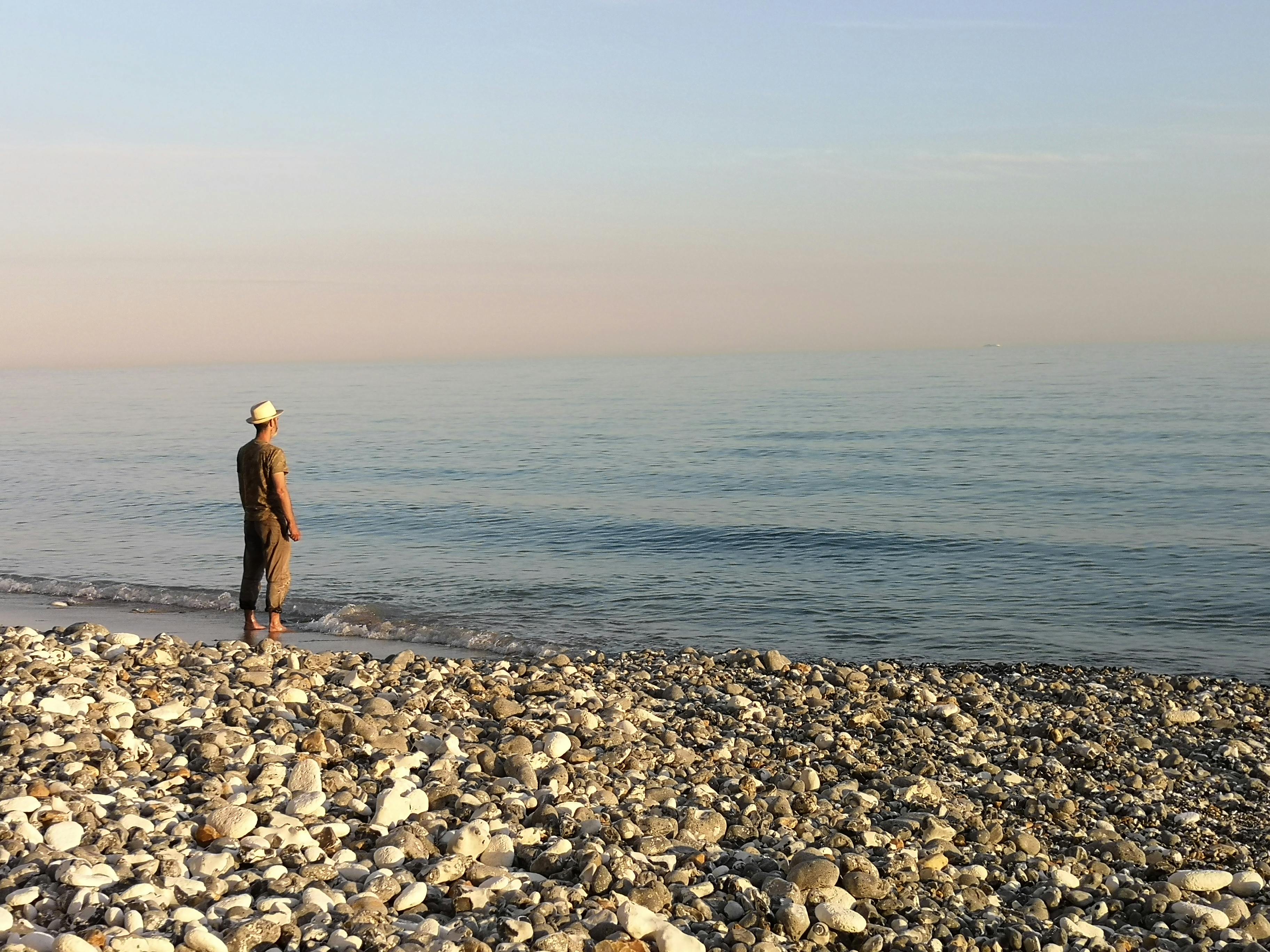 Photo Of Man Standing On Seashore · Free Stock Photo