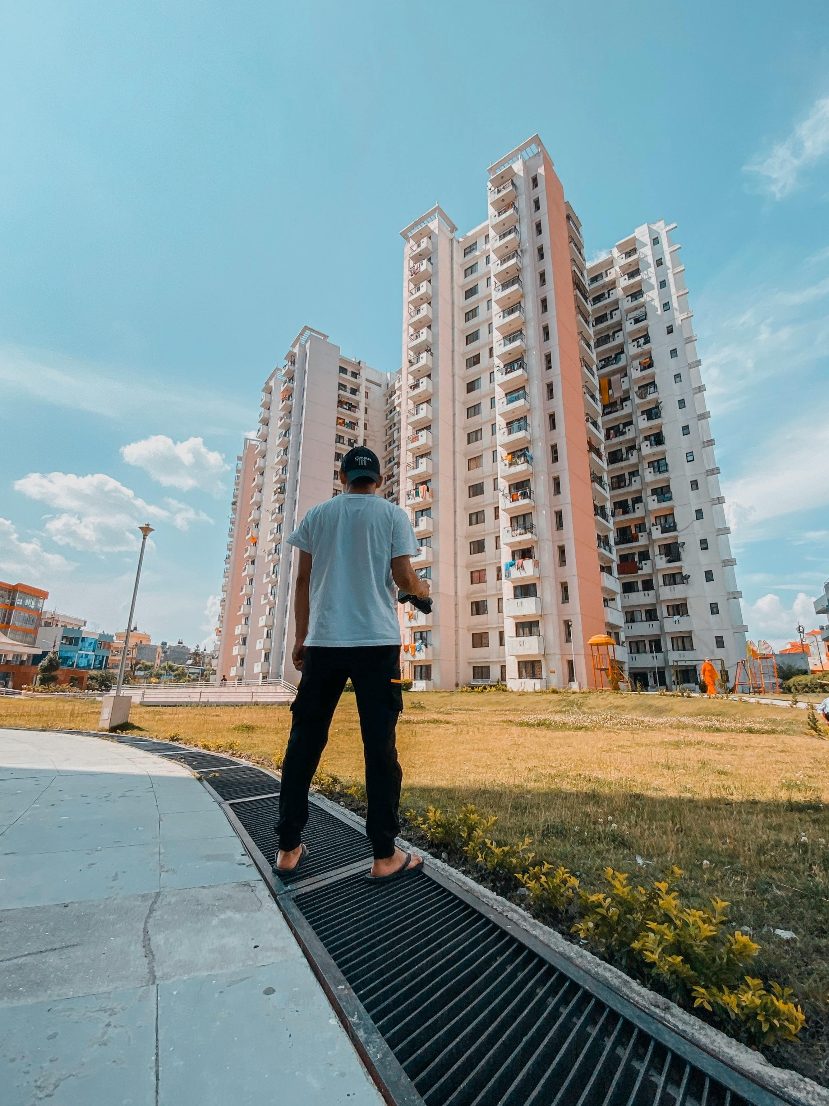 Unrecognizable man standing on street against modern residential ...