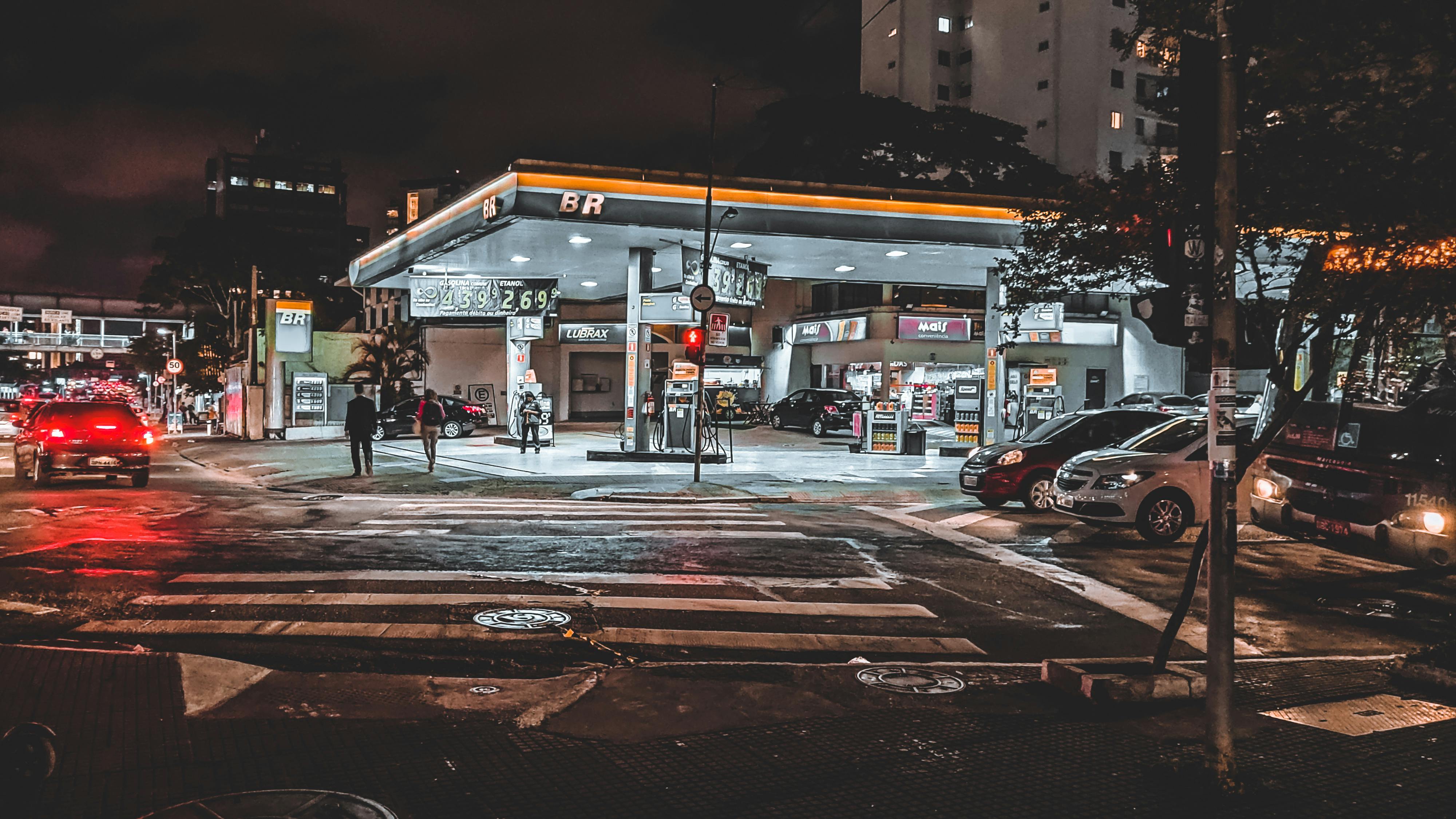 Busy urban street with traffic on and gas station near · Free Stock Photo
