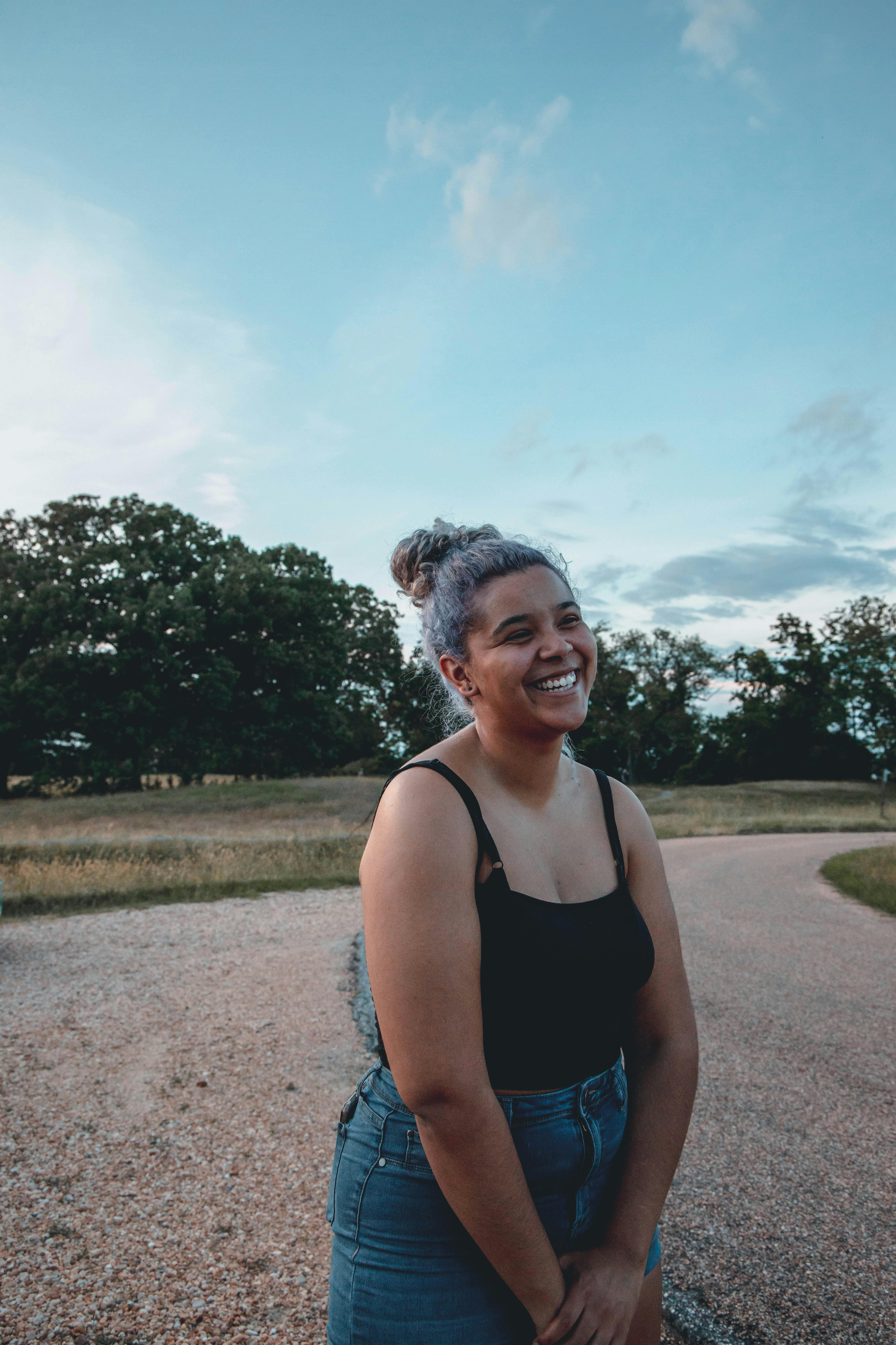 Positive plump ethnic woman on road near meadow · Free Stock Photo