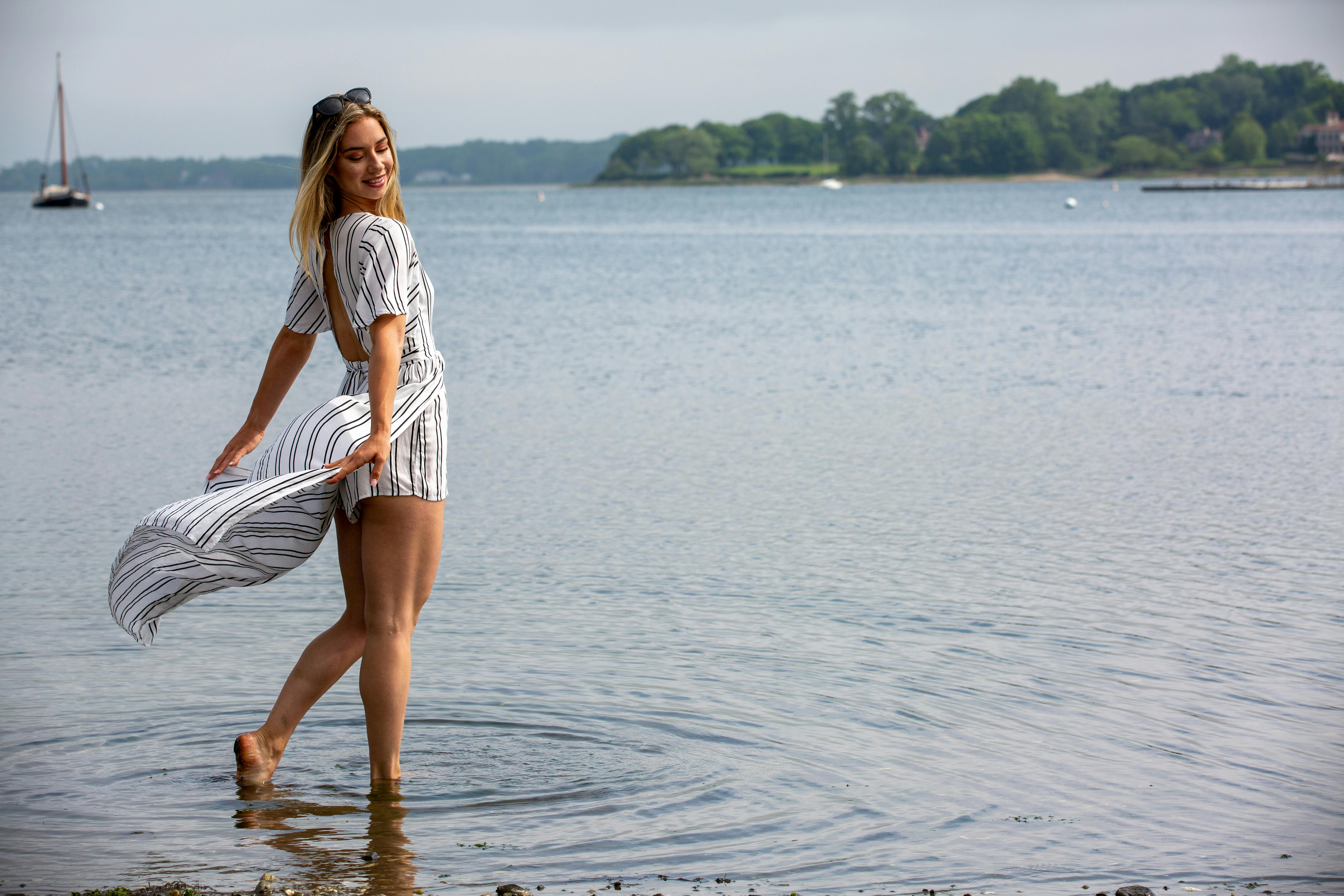 Trendy woman standing in shallow sea · Free Stock Photo