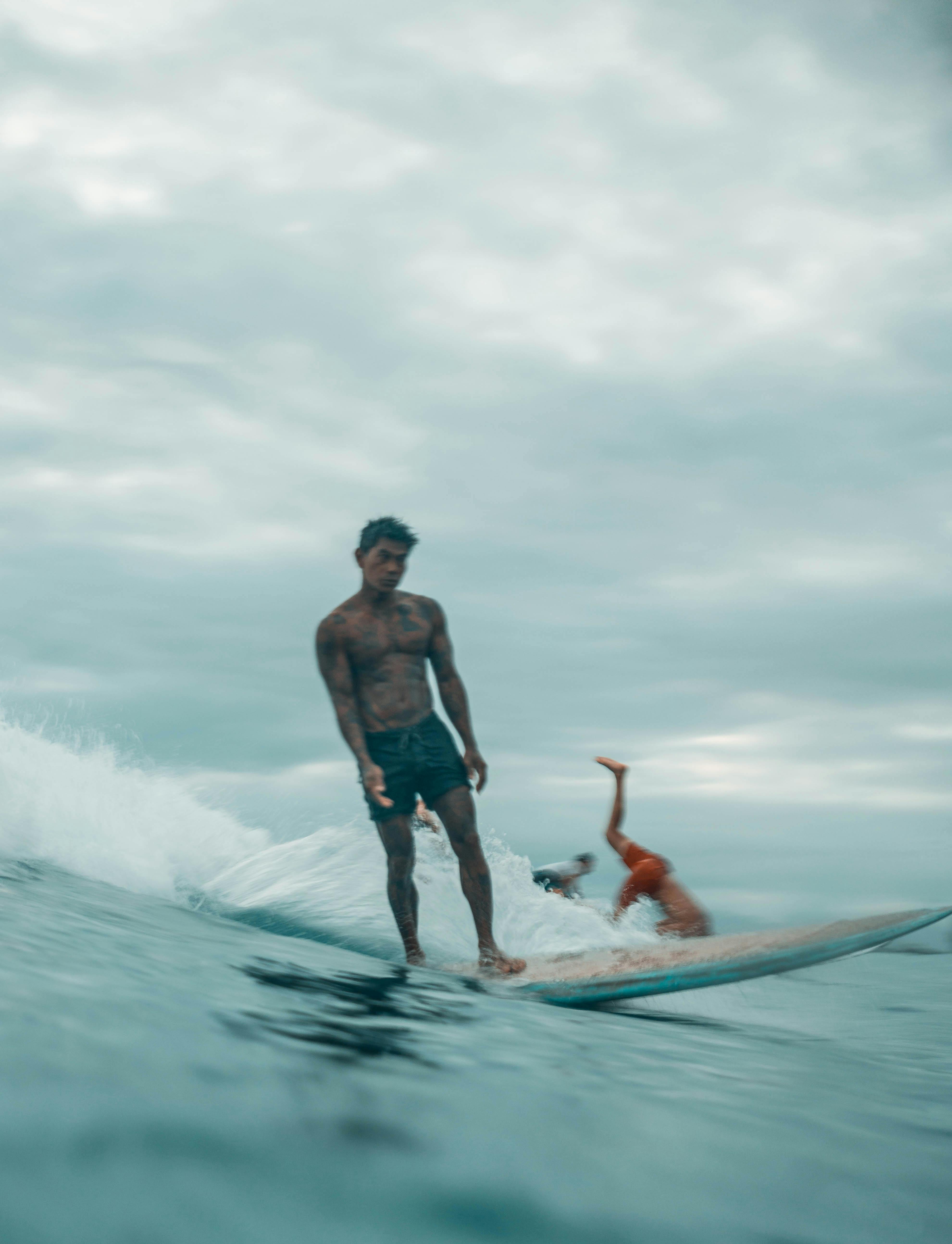 Focused male surfer lying on surfboard on seawater · Free Stock Photo