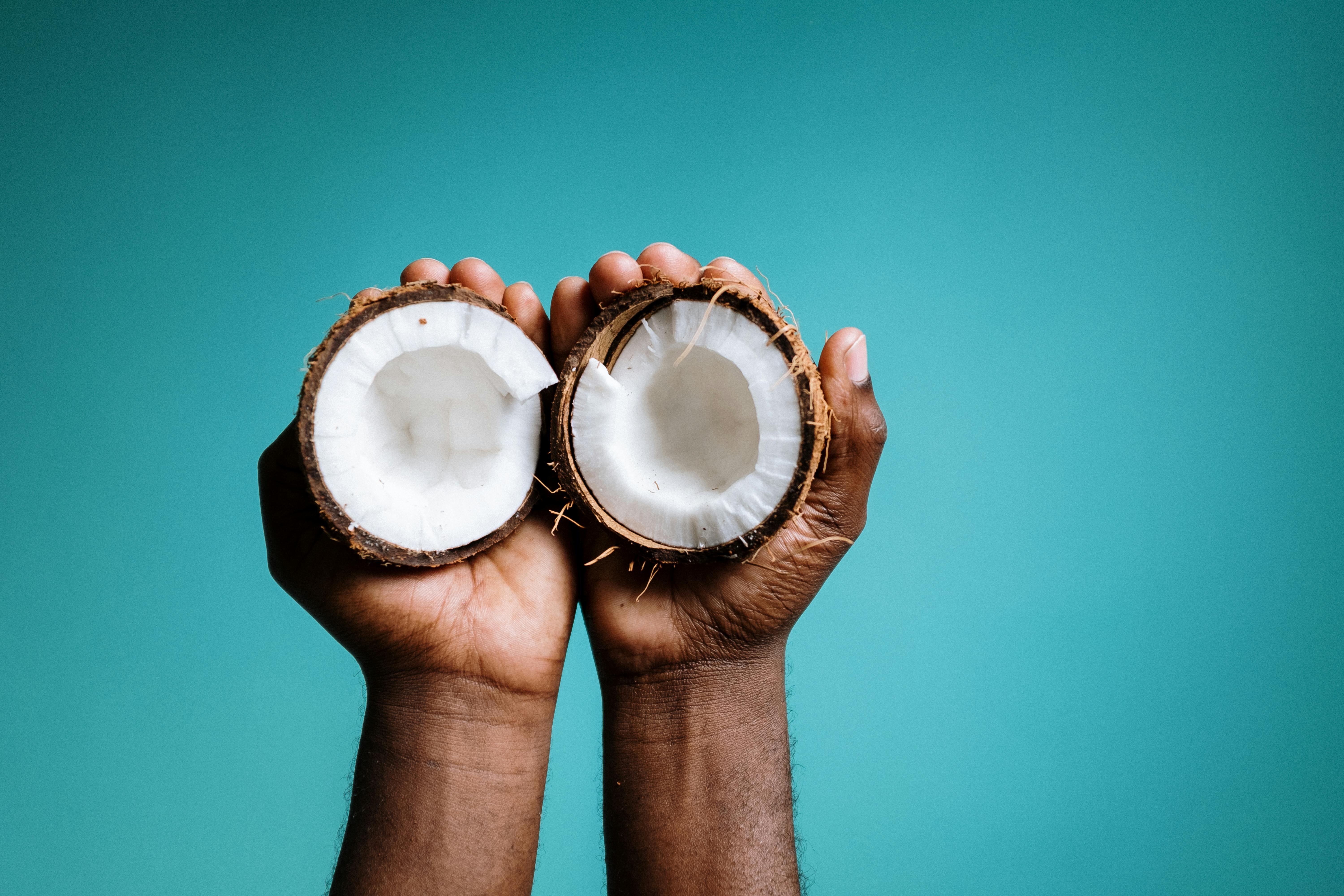 Photo Of Person Holding Sliced Coconut · Free Stock Photo