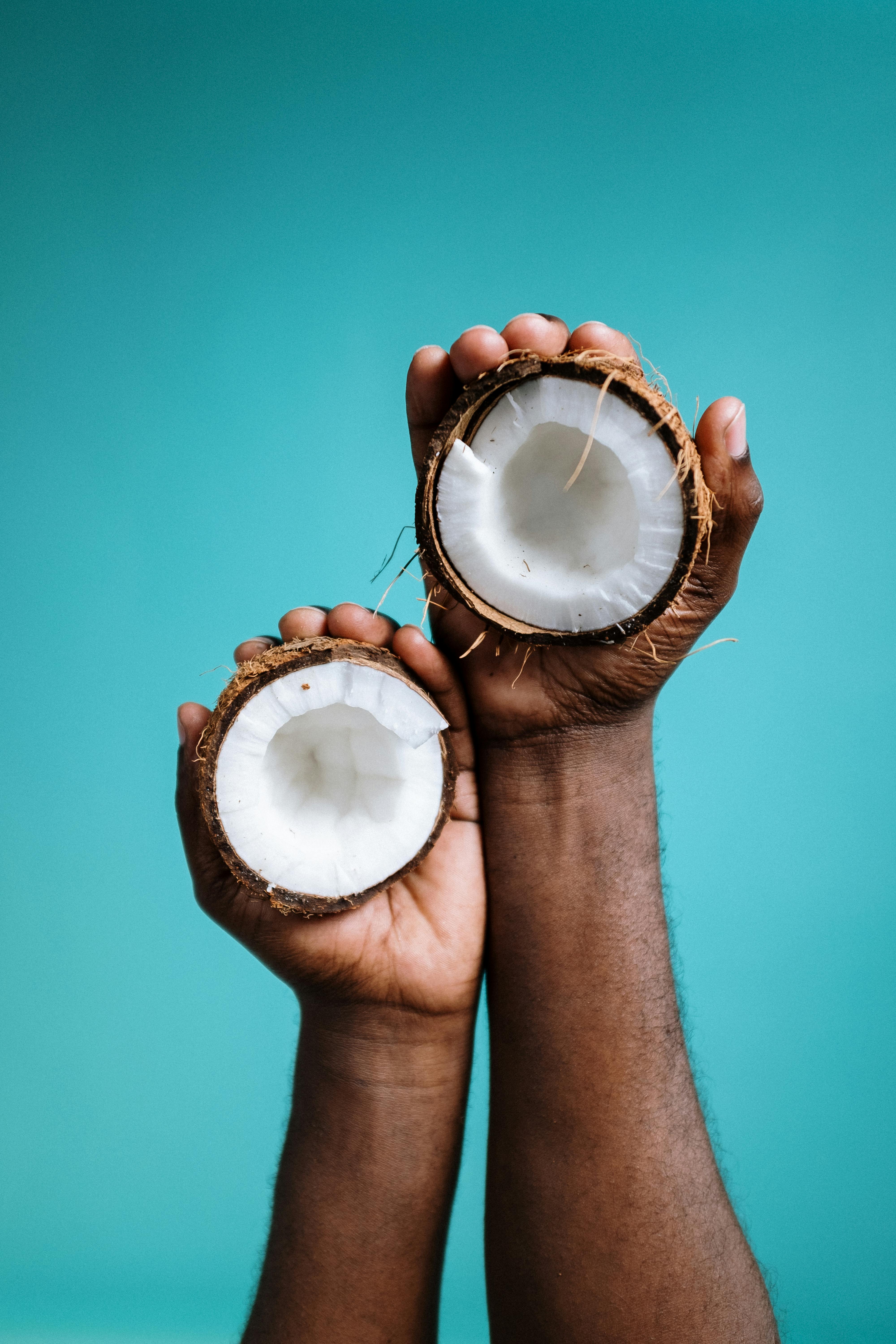 Photo Of Person Holding Sliced Coconut · Free Stock Photo