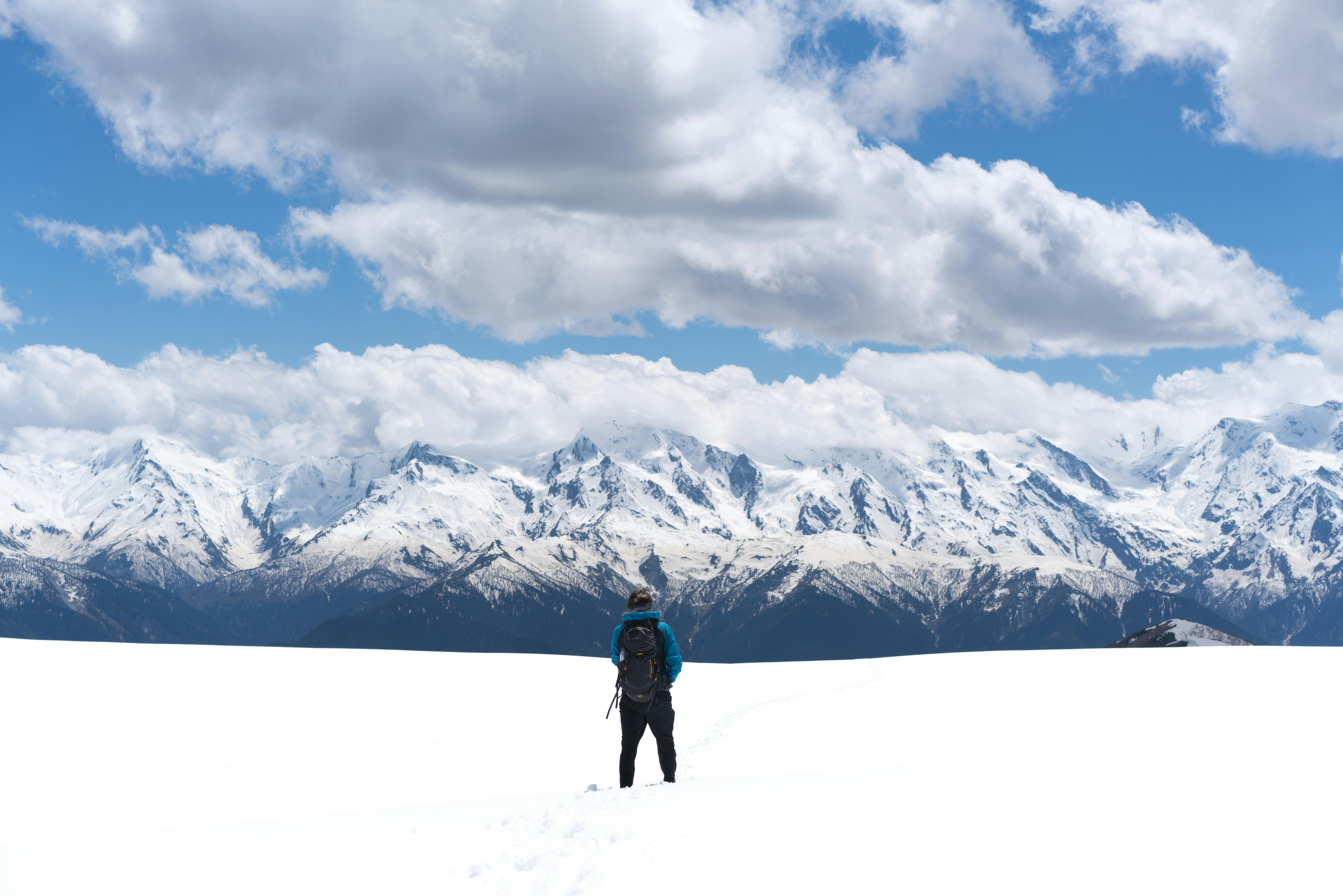 Man Standing on Snow with Perfect Snowy Mountain View · Free Stock Photo