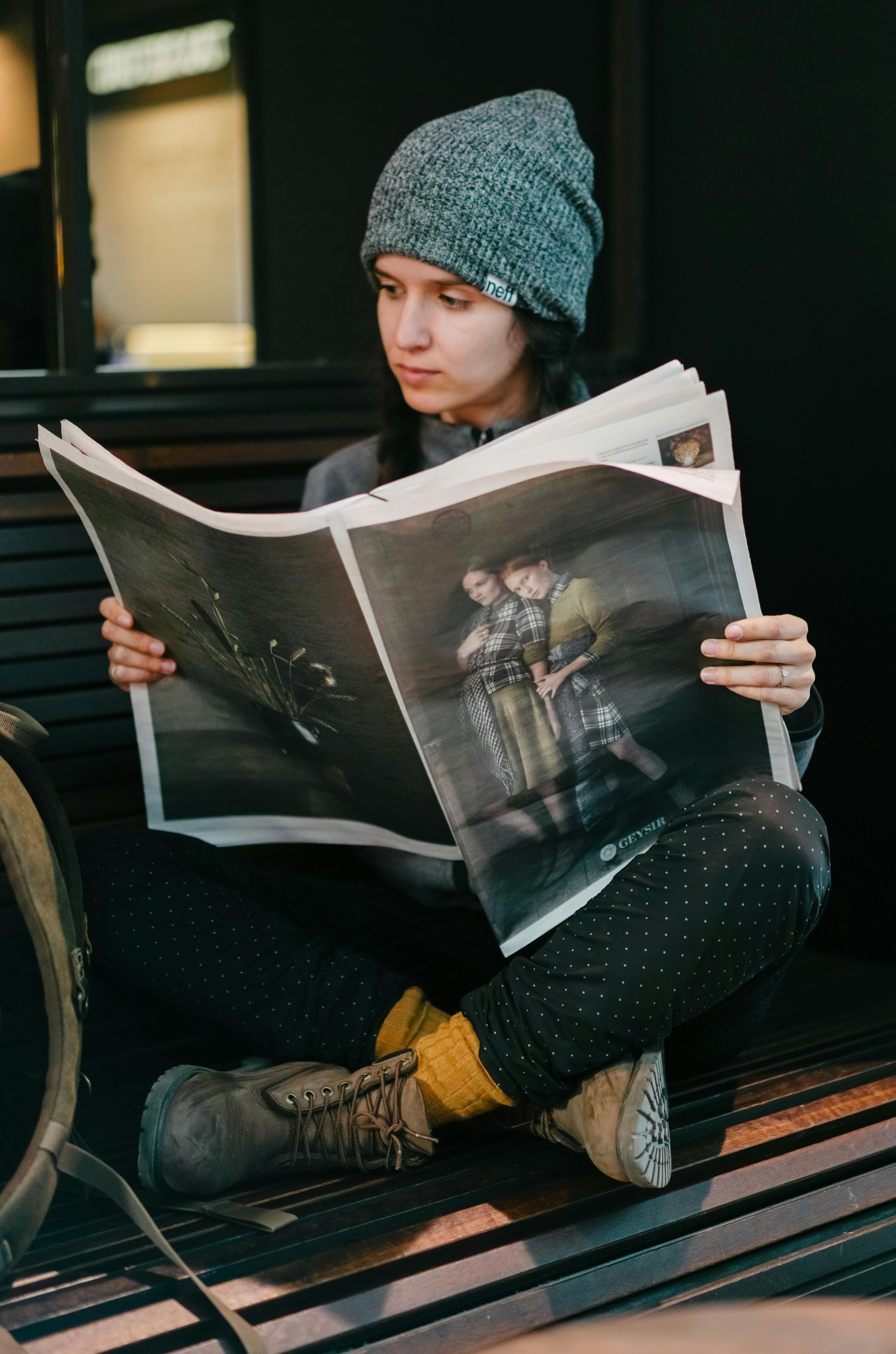Photo of Woman Sitting While Reading Newspaper · Free Stock Photo