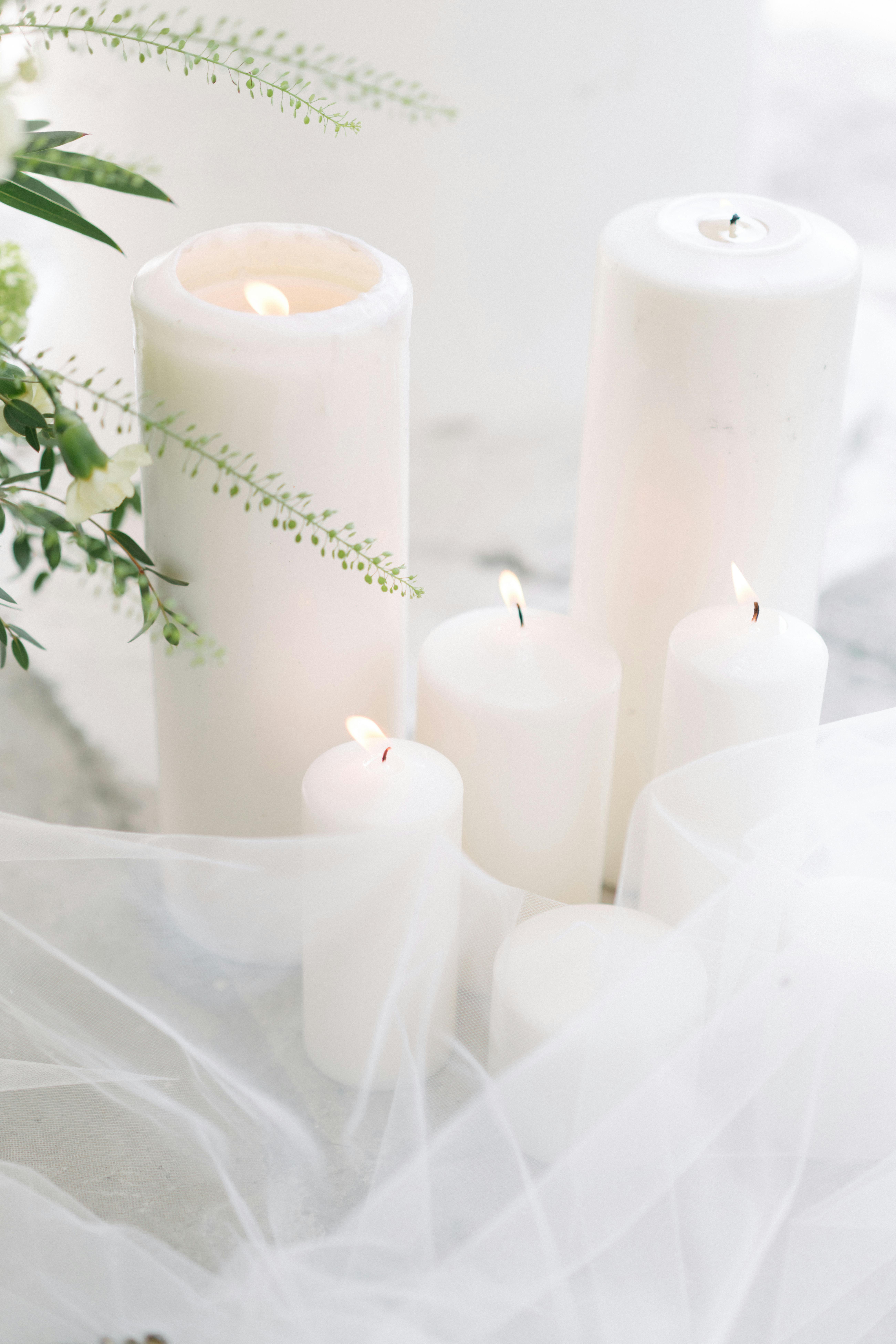 White Lighted Candles Beside a White Sheer Fabric · Free Stock Photo