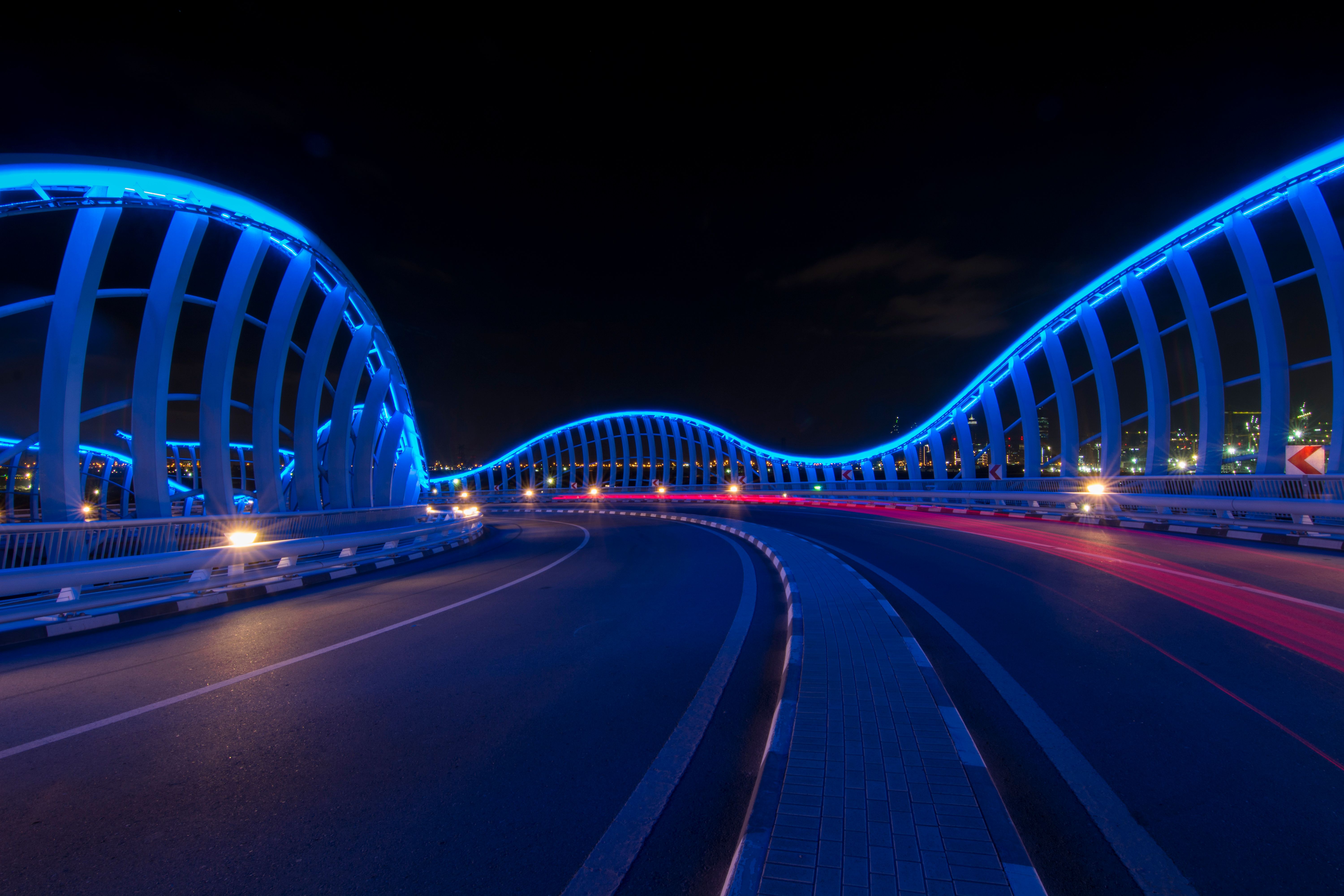 Illuminated Metal Railings Along an Asphalt Road · Free Stock Photo