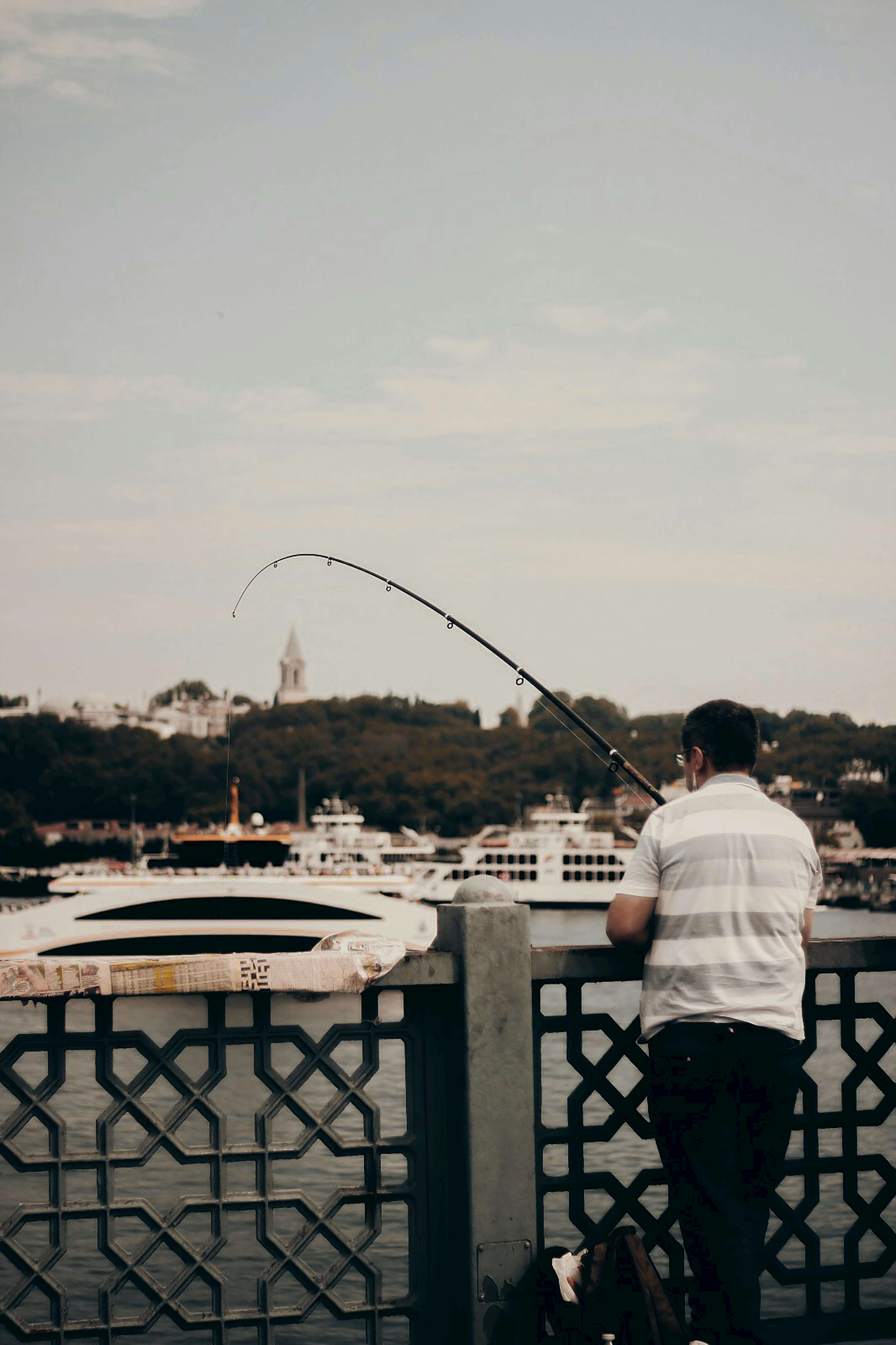 A Man Fishing from a Bridge · Free Stock Photo